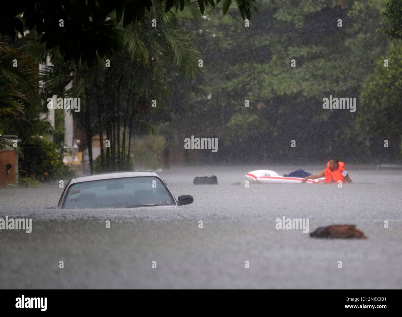 A private guard searches homes to rescue residents trapped in a flooded ...