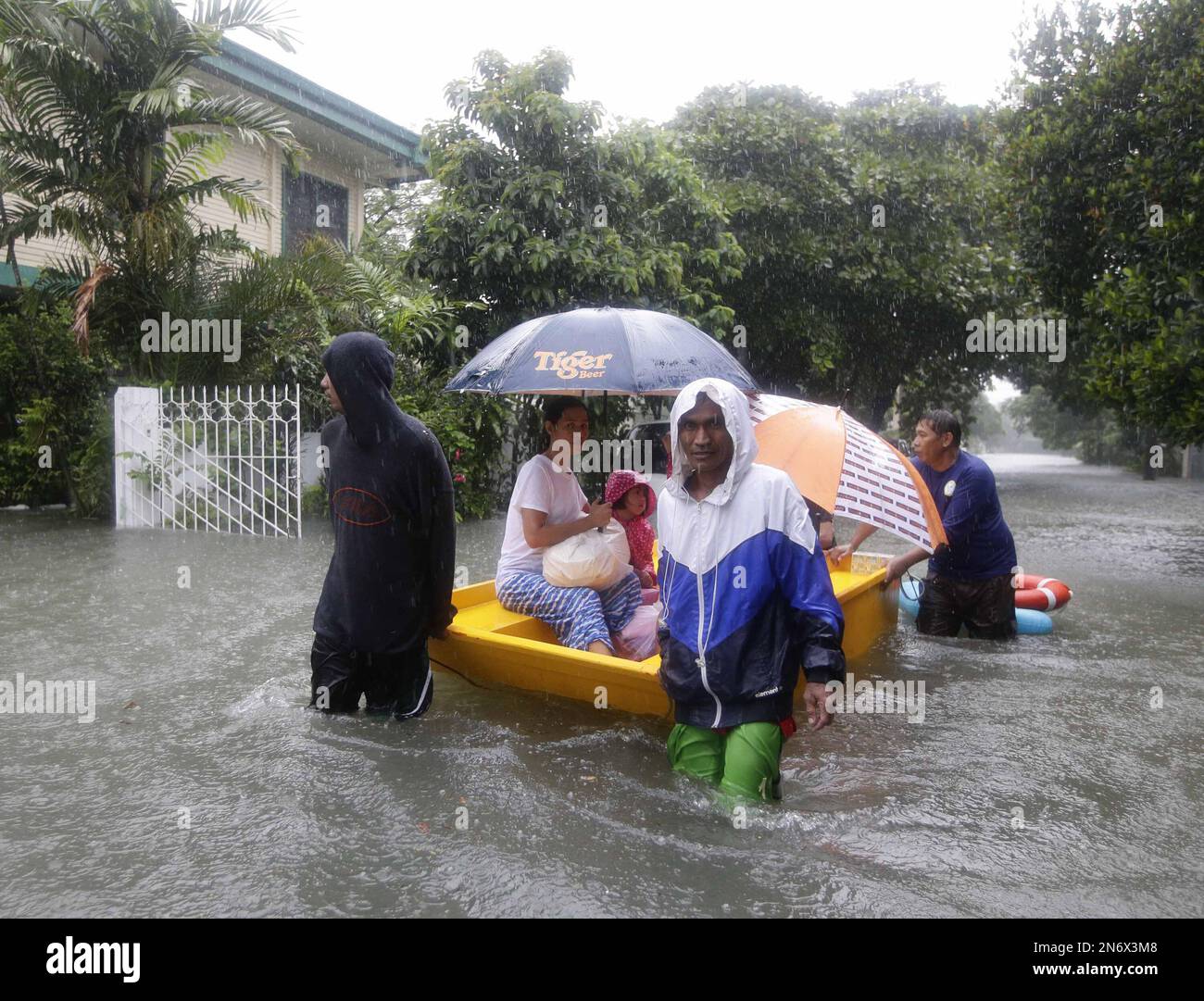 Volunteers rescue residents trapped in a flooded street at a ...