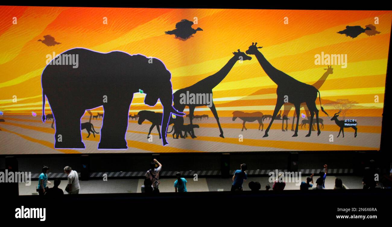 Visitors watch the life-size projections of animals Monday, Aug. 19 ...