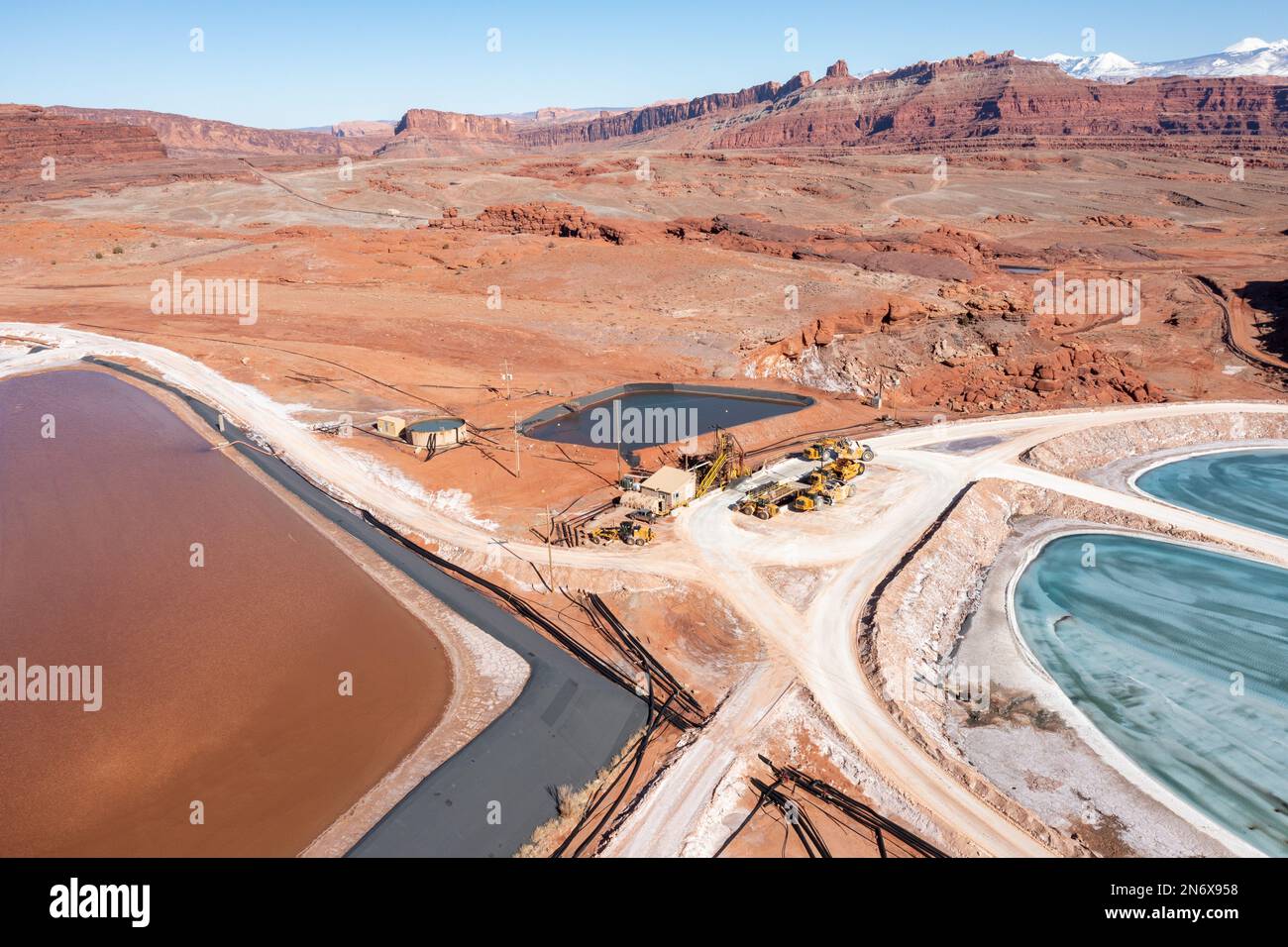 A heavy-duty scraper dumping a load of potash from an evaporation pond ...