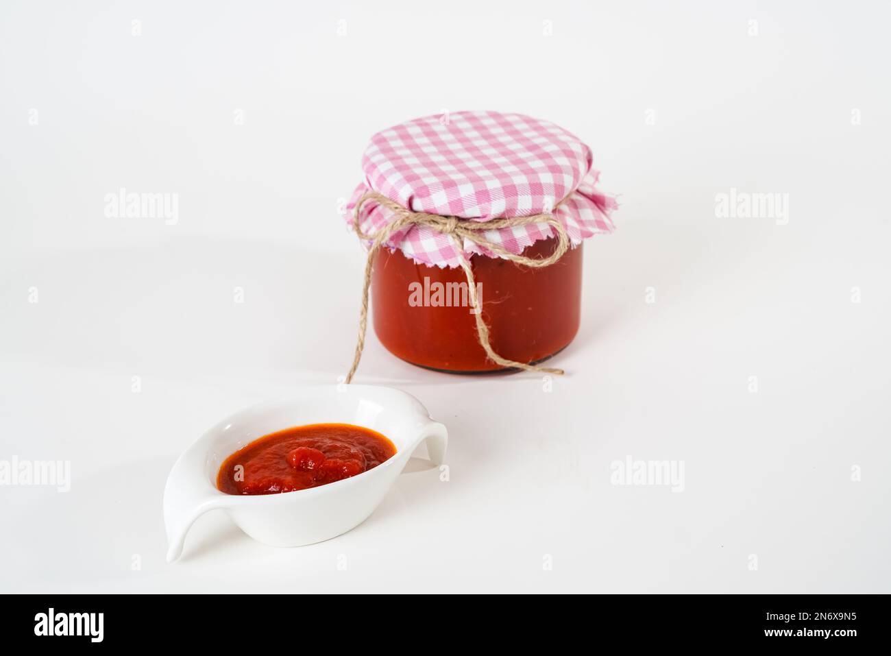Traditional homemade chili tomato sauce in glass jar and small pot ...