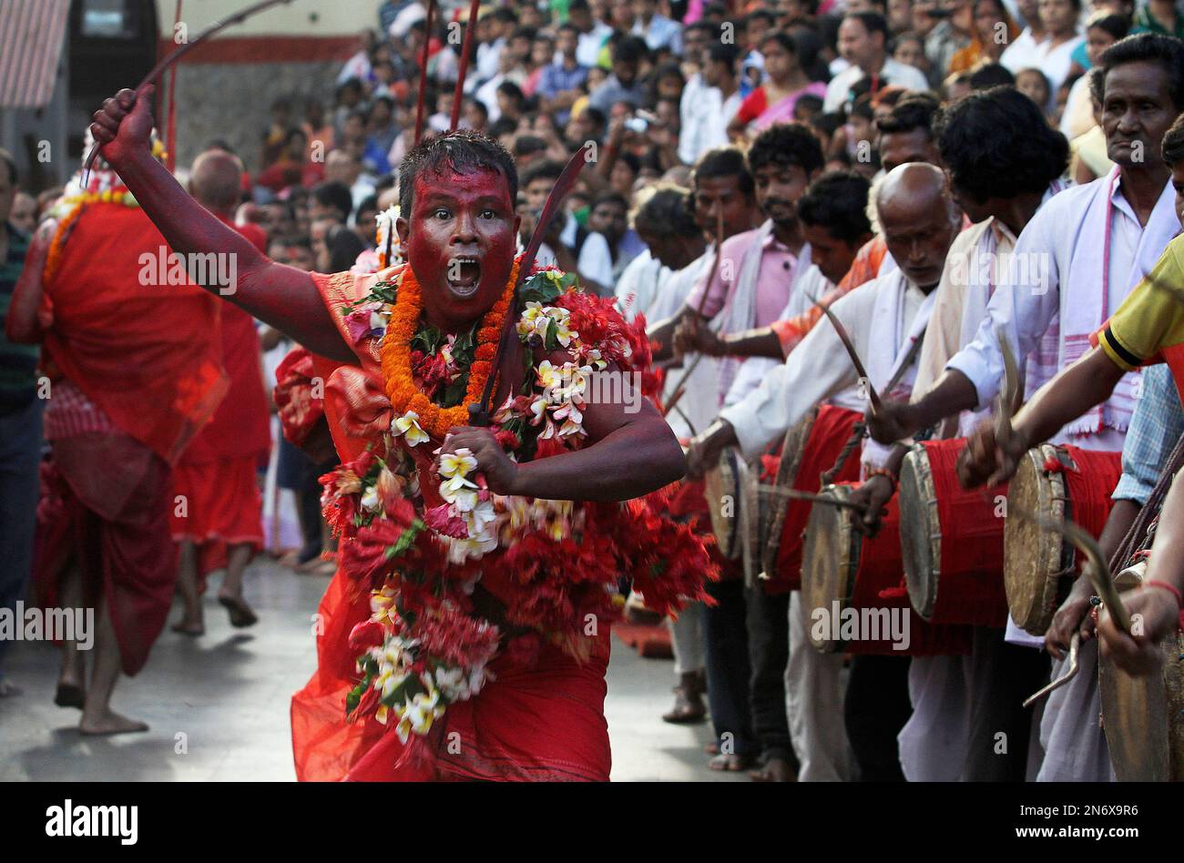 A Hindu priest, face smeared with color and sacrificial blood, performs ...