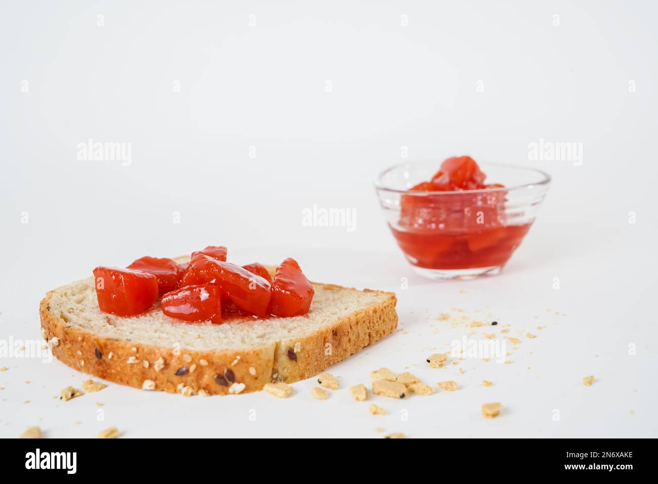 Homemade quince jam, small bowl and a slice of bread with jam isolated ...