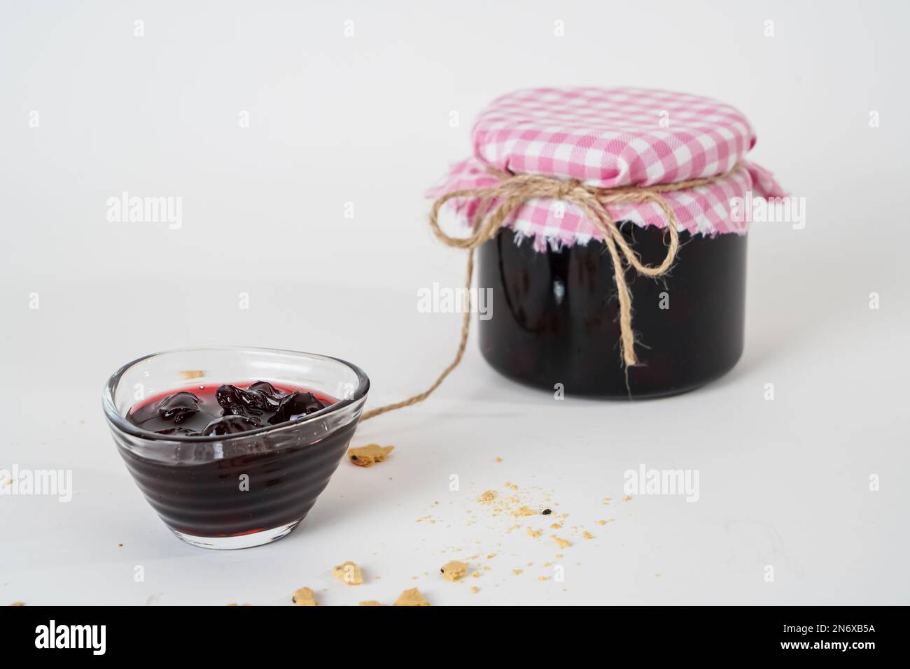 Homemade sour cherry jam, jar and small bowl with jam isolated on white ...