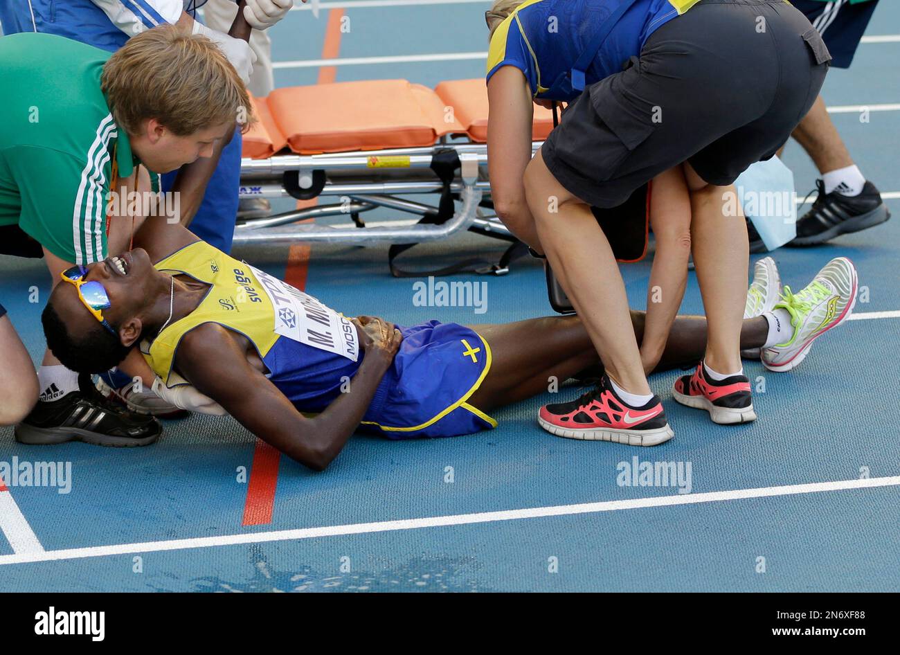 Sweden's Mustafa Mohamed is assisted after collapsing at the finish ...
