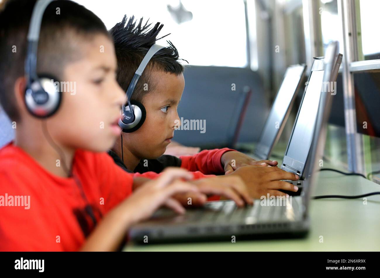 In this photo taken July 15, 2013, children play on computers after ...