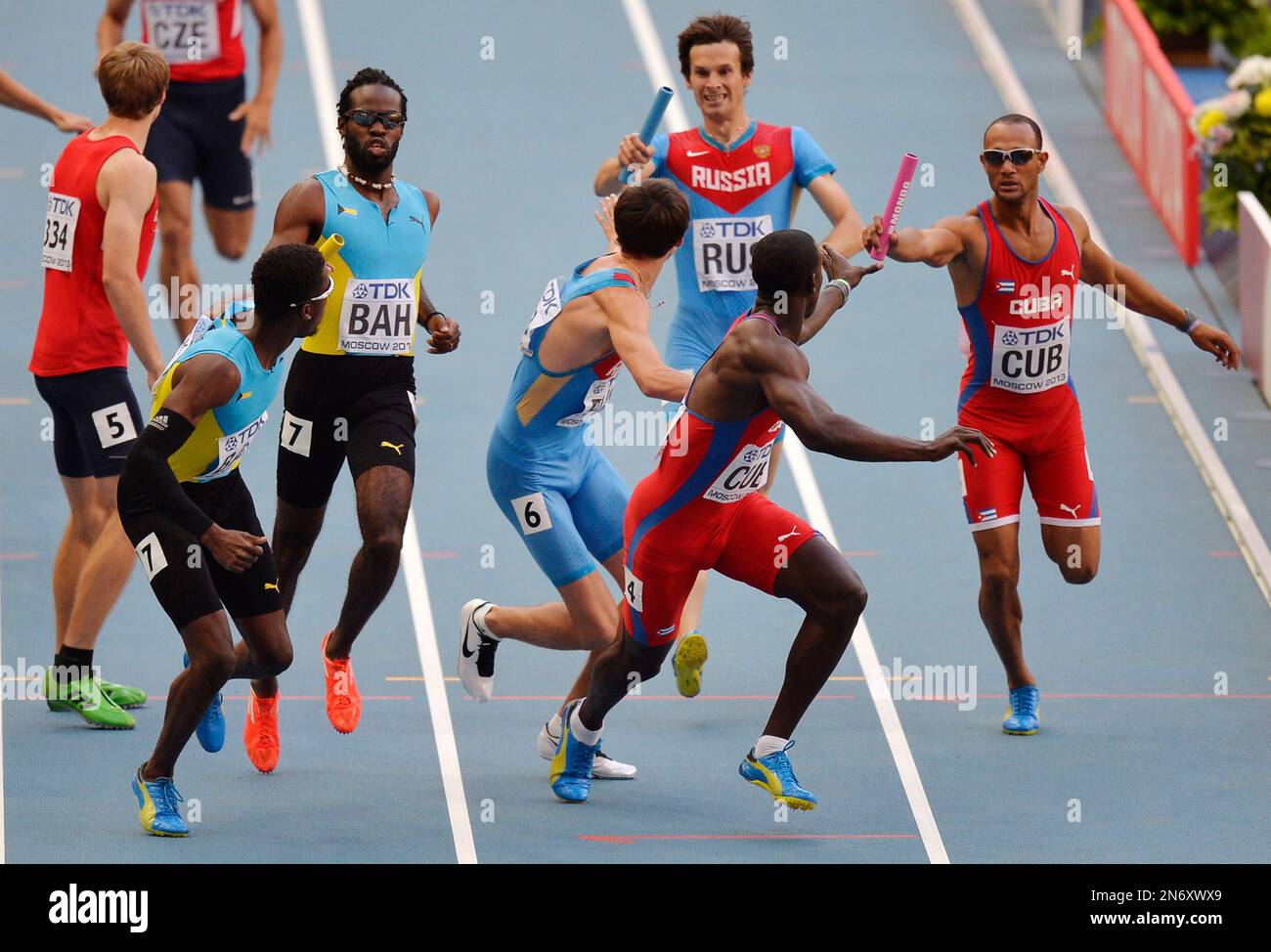 Athletes exchange the baton during a handover as they compete in the ...