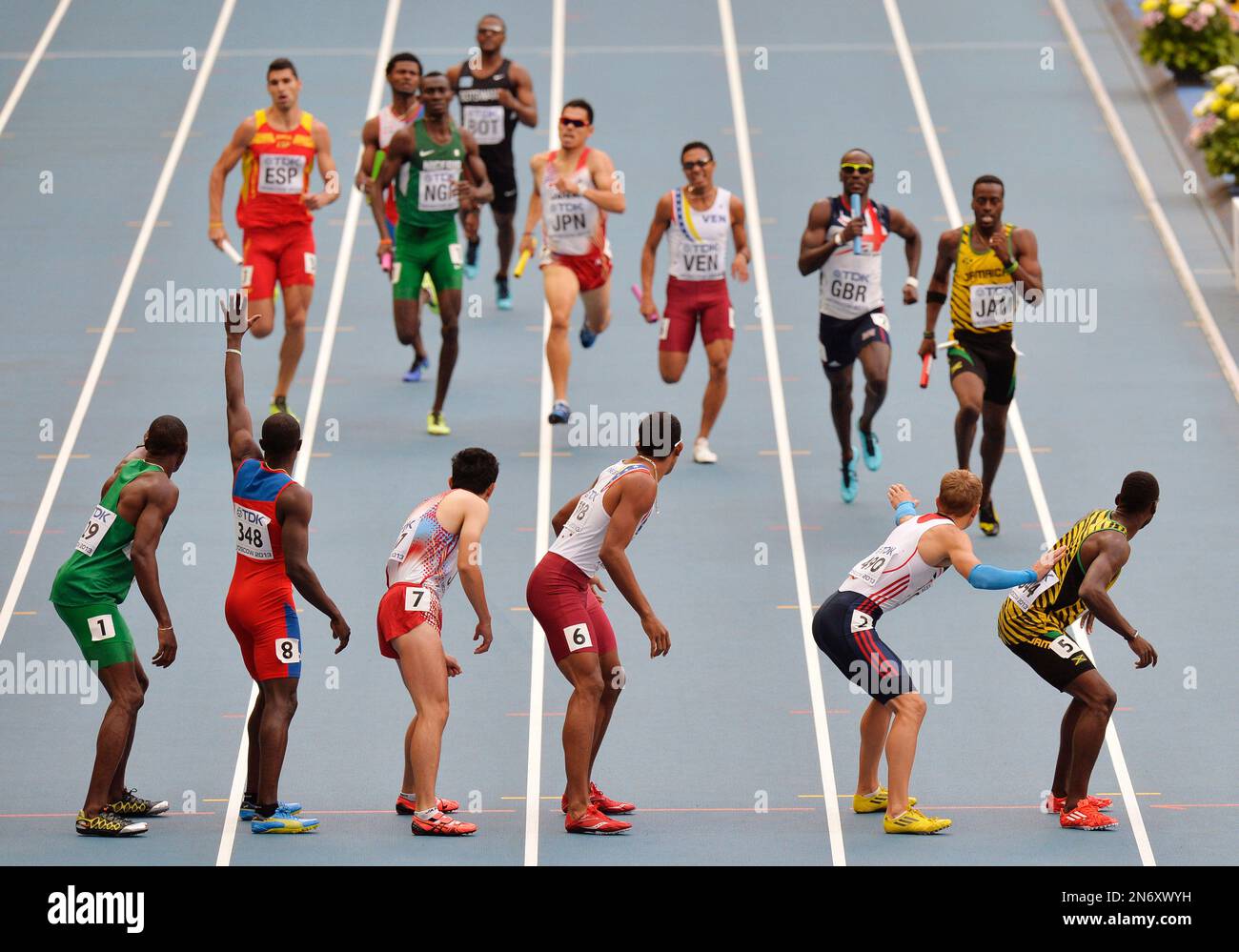 Athletes wait for the baton handover as they compete in a men's 4x400 ...