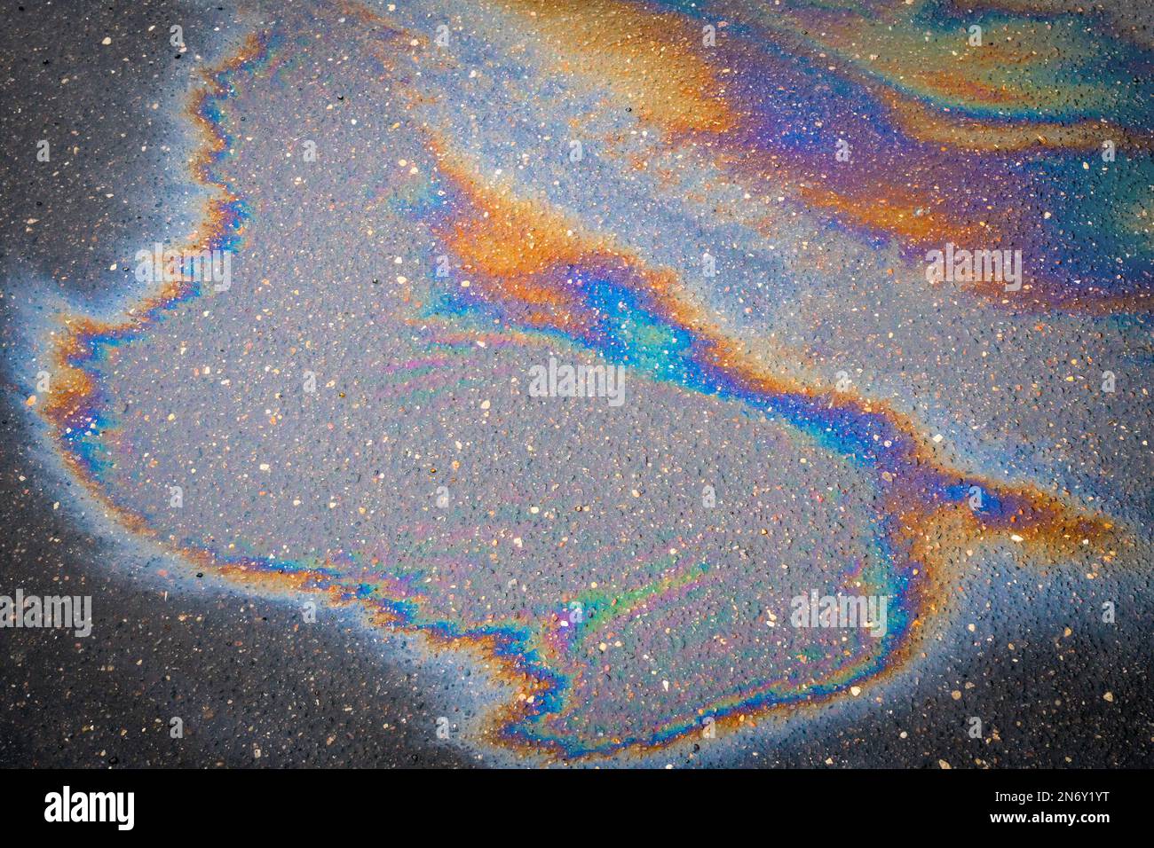 Colored texture of oil products on the asphalt in the rain. Oil dripped ...