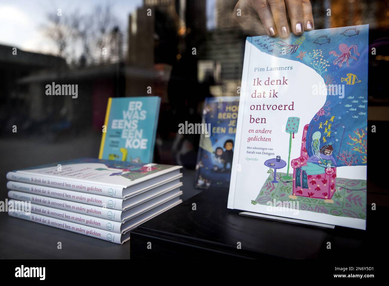 ROTTERDAM - An employee of a bookshop places a book by Pim Lammers in ...