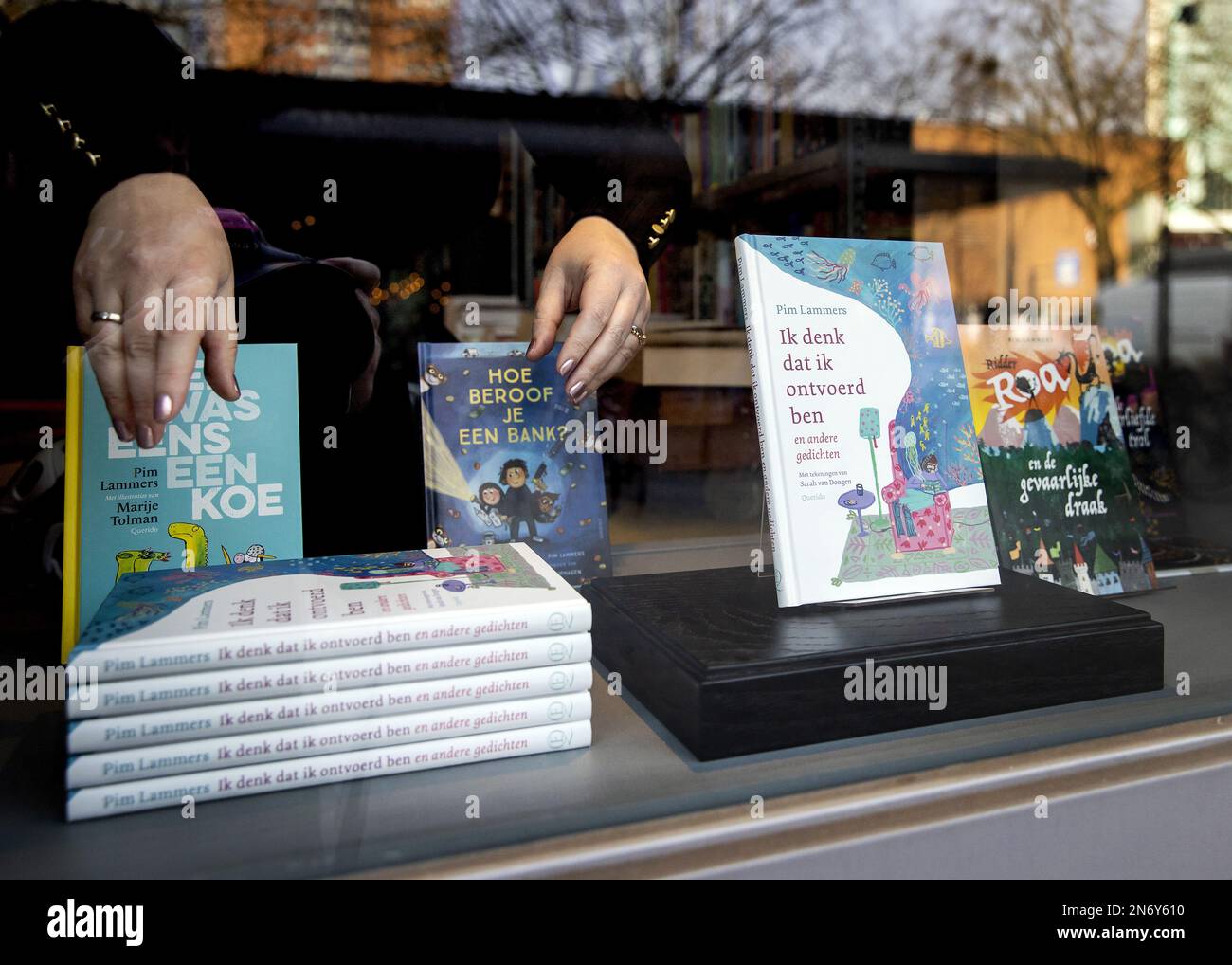 ROTTERDAM - An employee of a bookshop places a book by Pim Lammers in ...