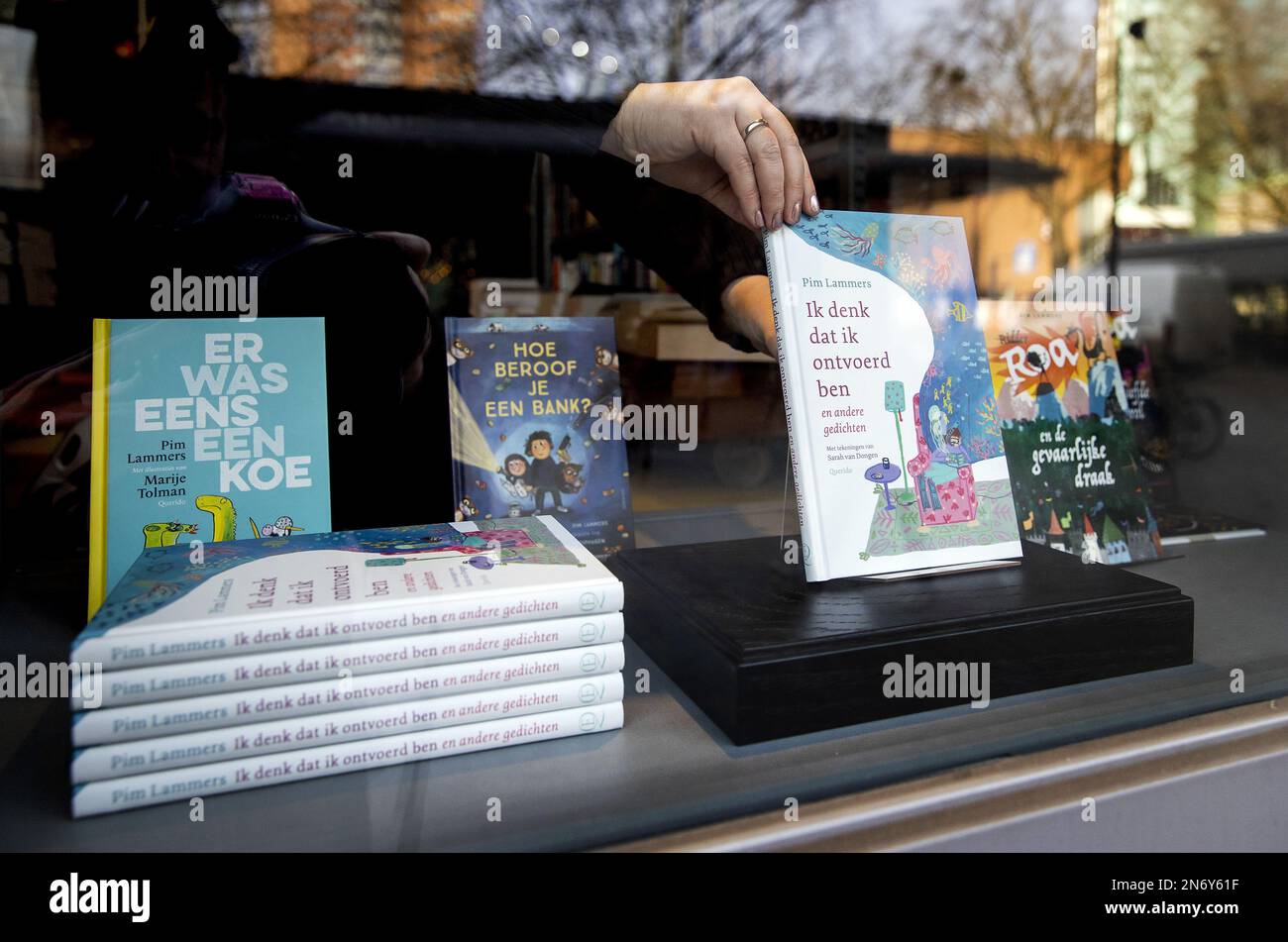 ROTTERDAM - An employee of a bookshop places a book by Pim Lammers in ...
