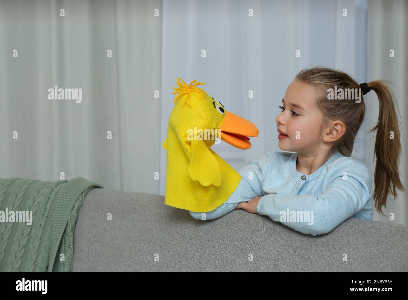 Cute little girl performing puppet show at home Stock Photo - Alamy