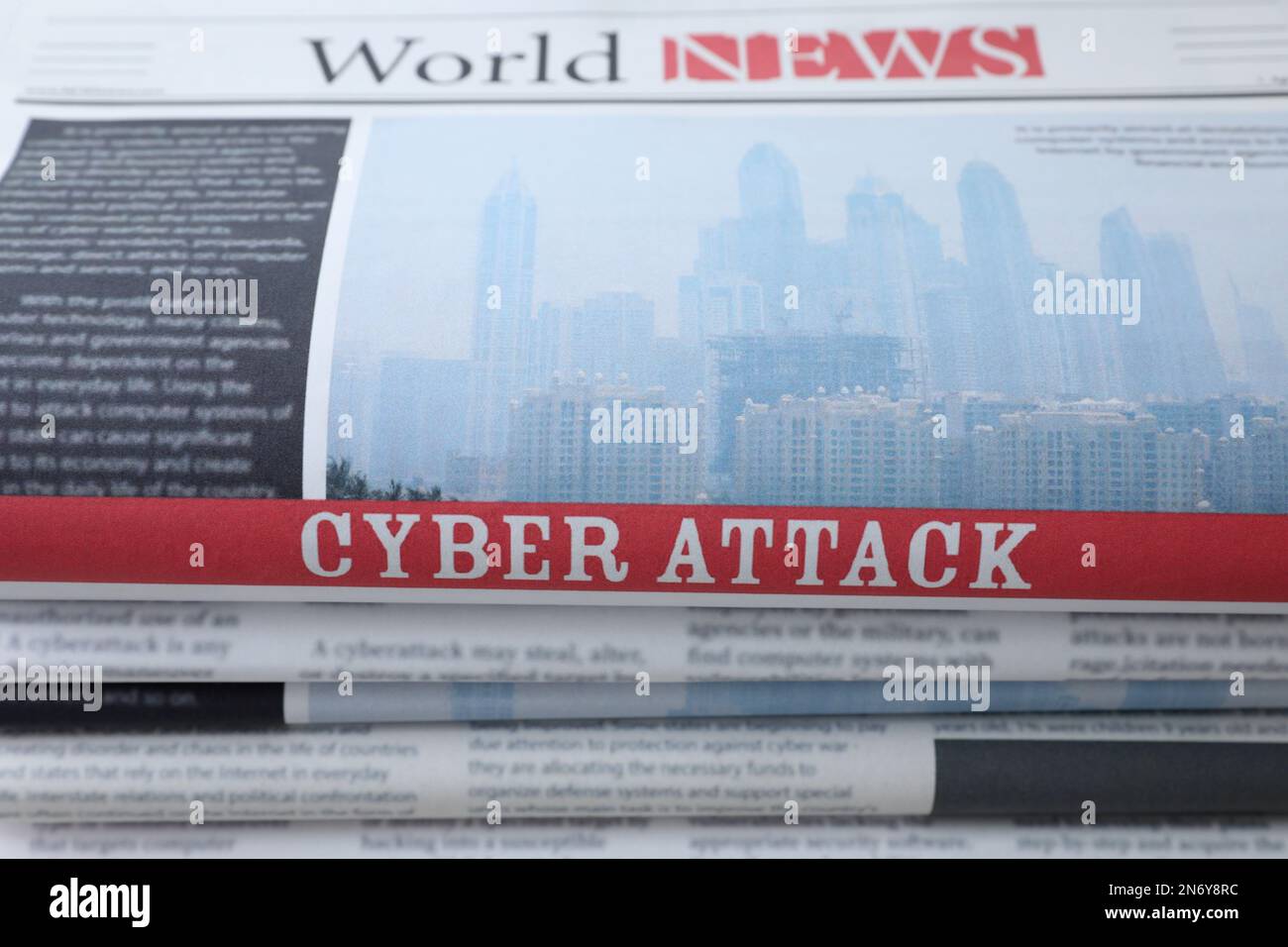 Stacked newspapers with headline CYBER ATTACK as background, closeup ...