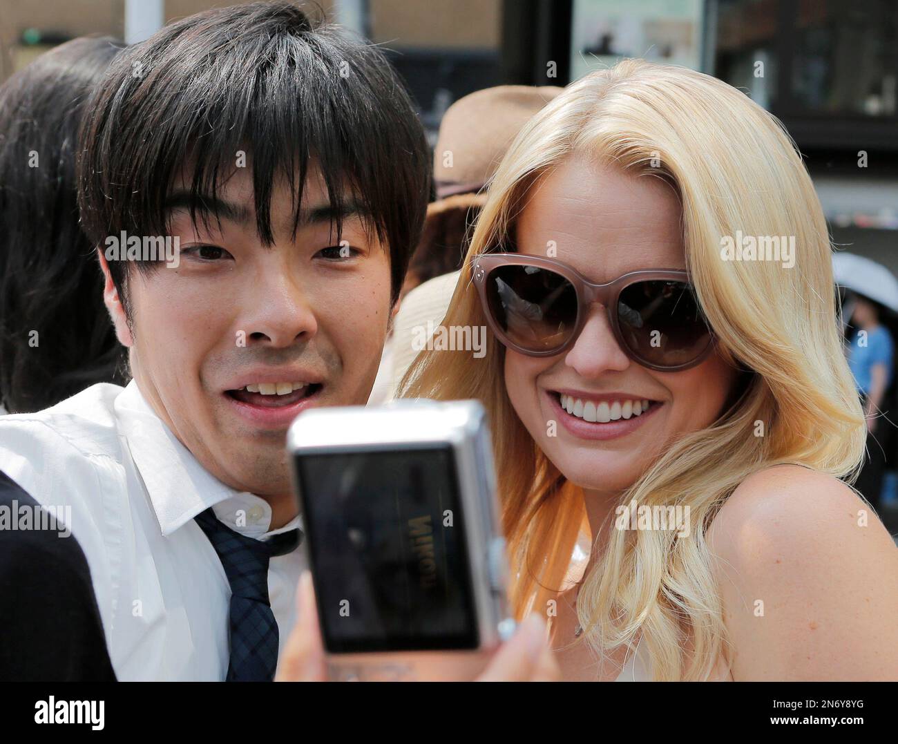 British actress Alice Eve poses for a photograph with a fan after a ...