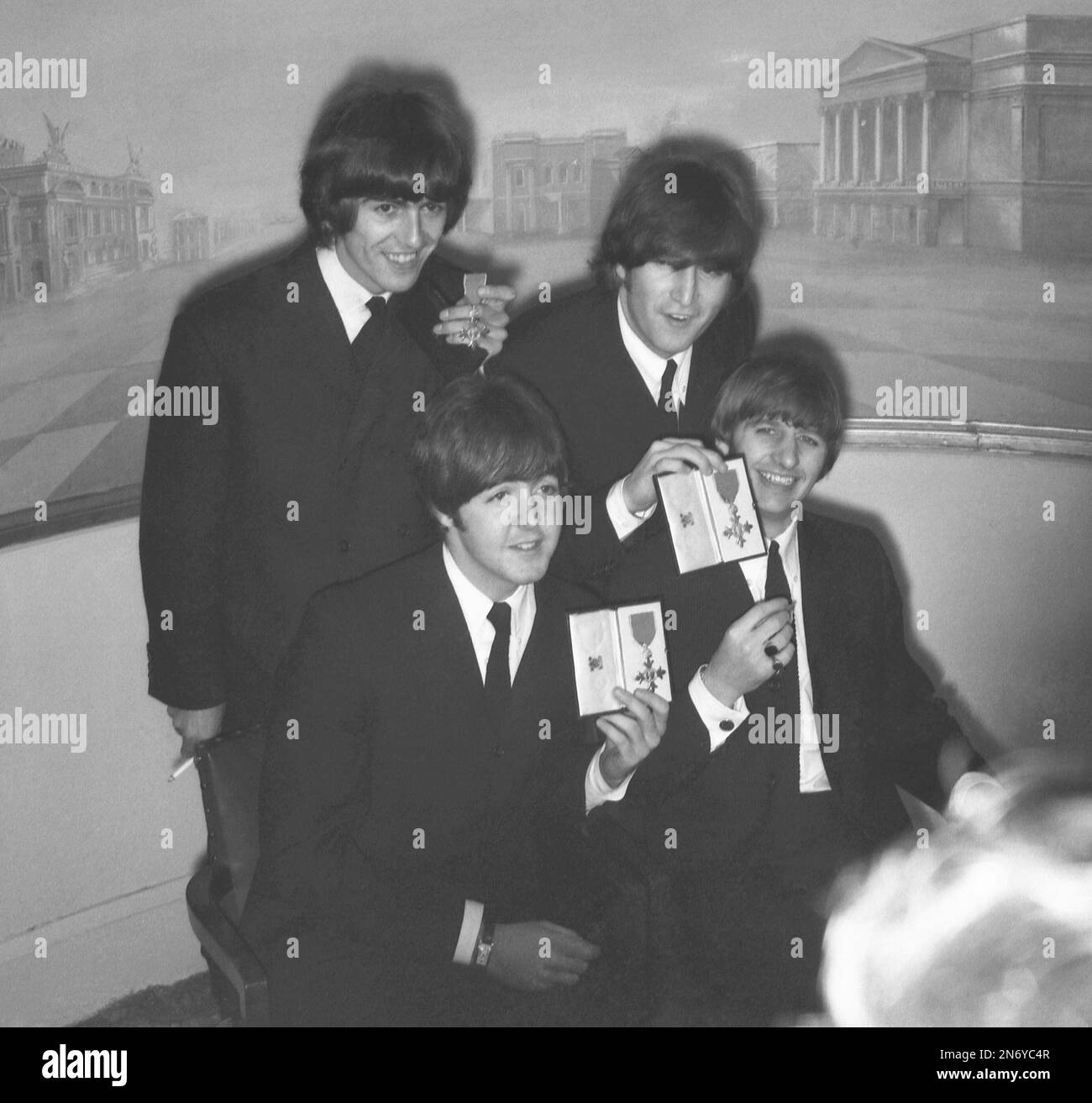 The Beatles show their medals during a press conference in London ...