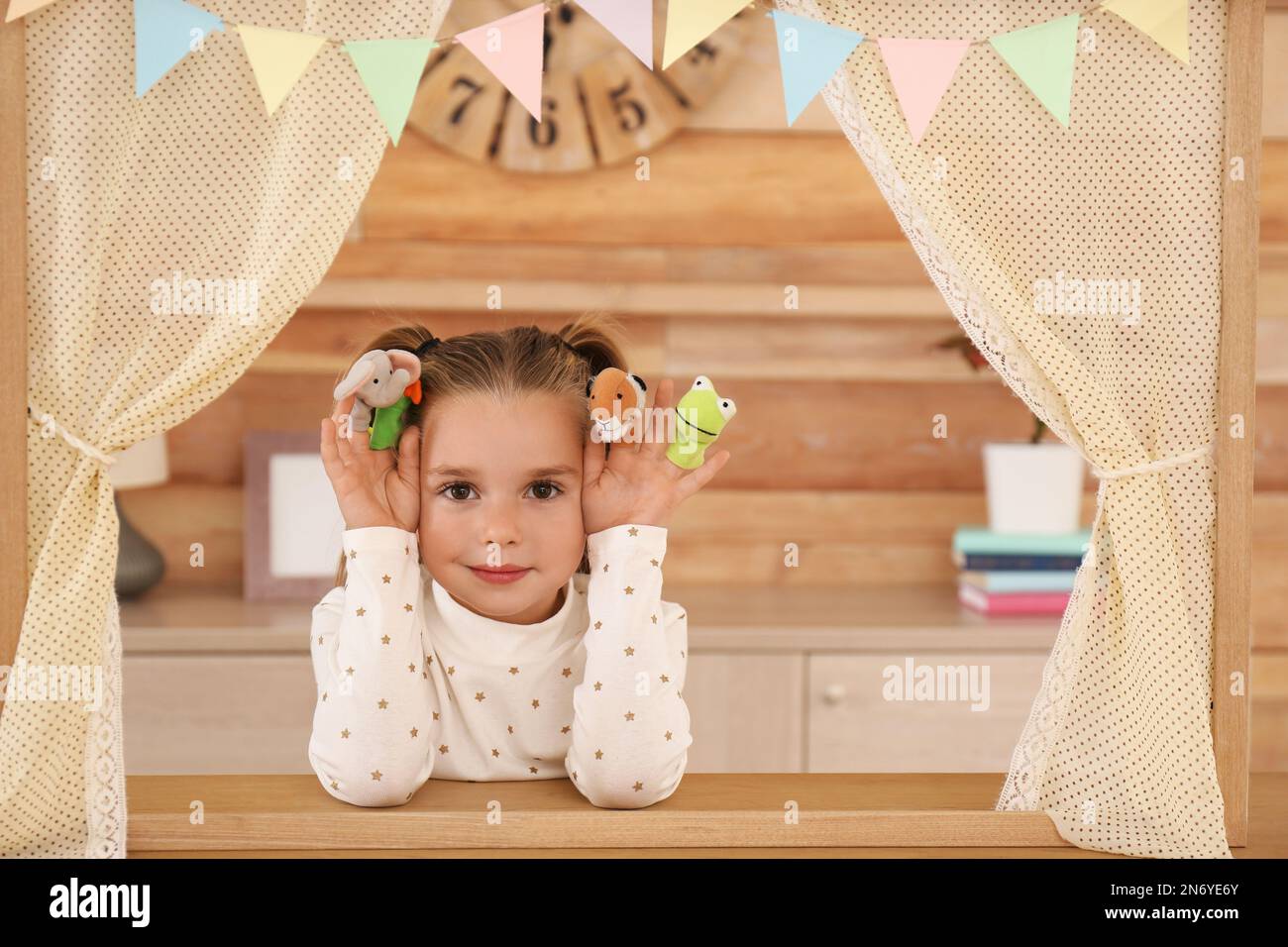 Cute little girl performing puppet show at home Stock Photo - Alamy