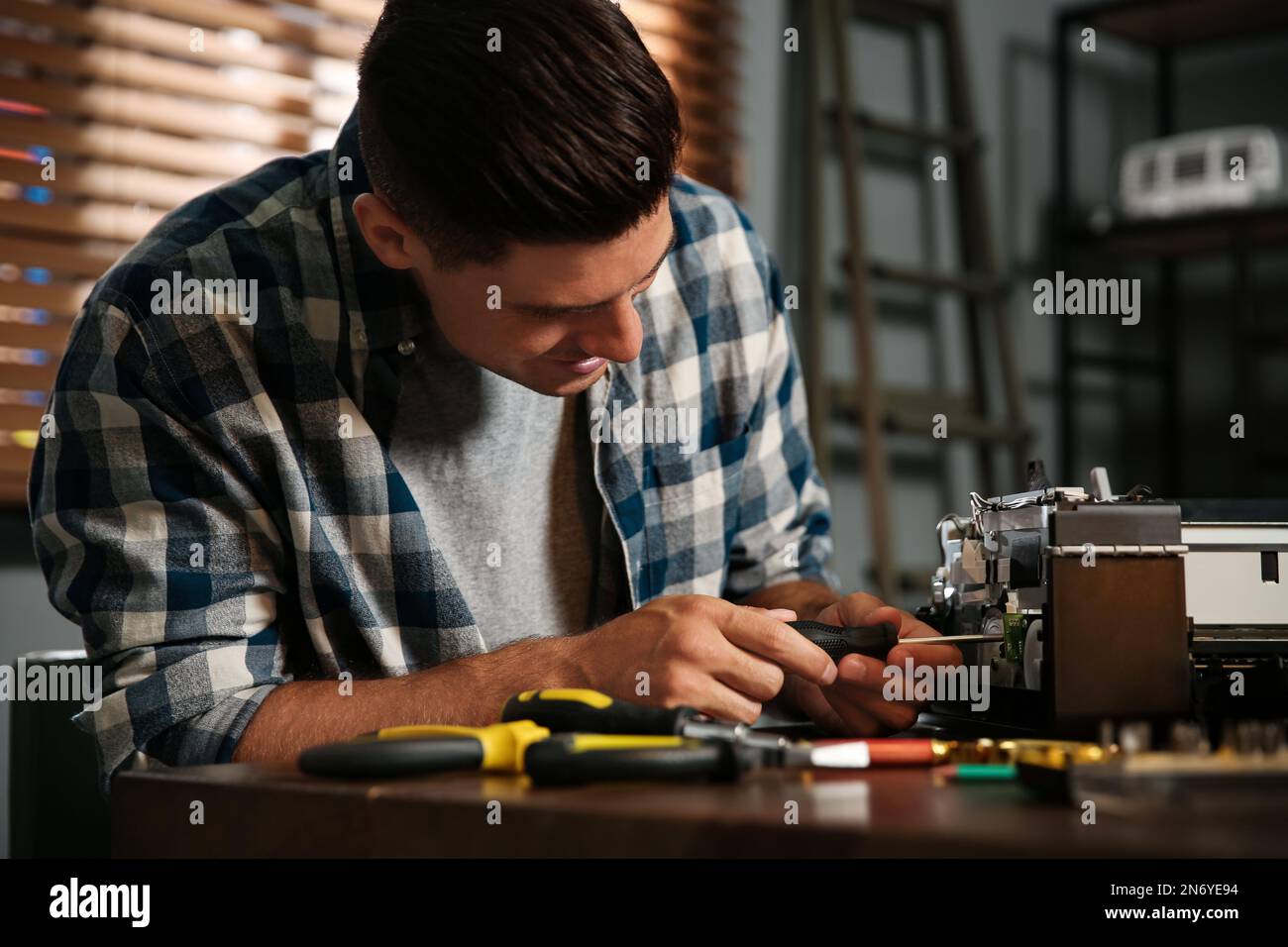 Repairman with screwdriver fixing modern printer in office Stock Photo ...