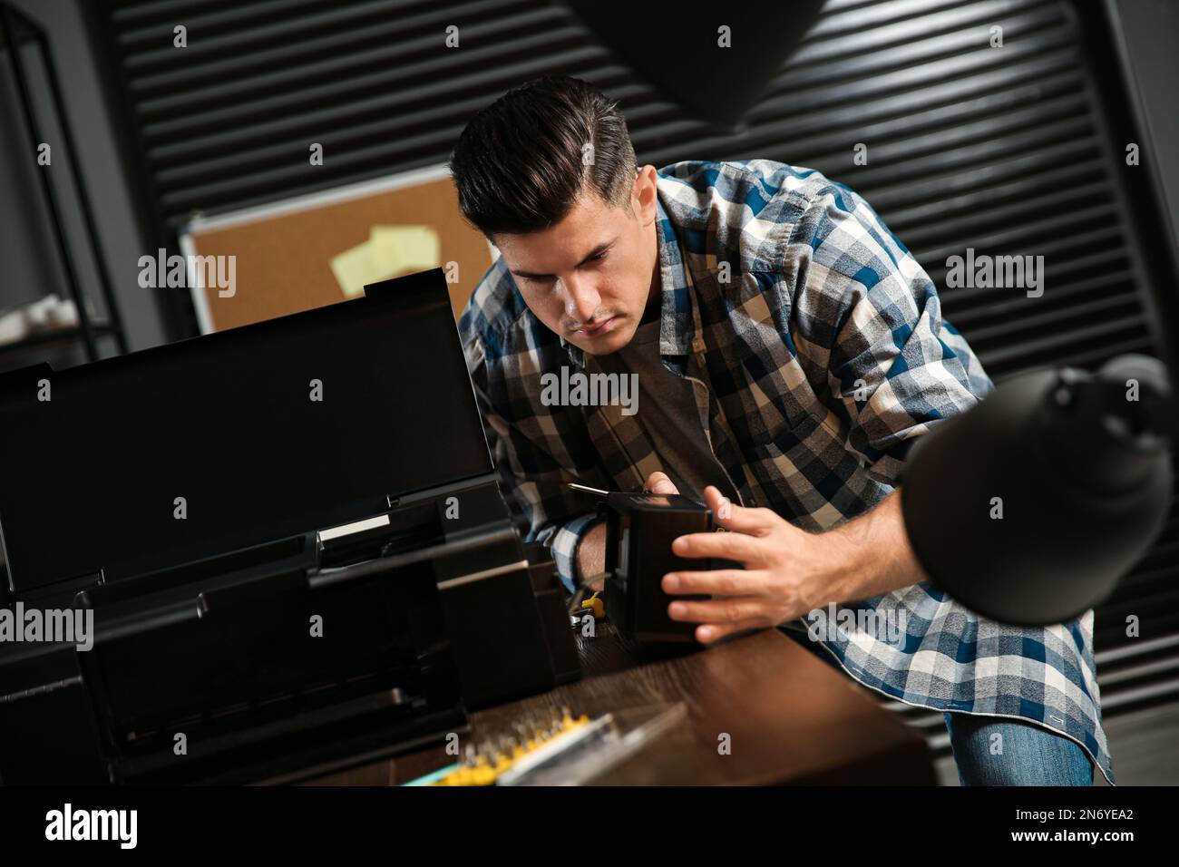 Professional repairman fixing modern printer in office Stock Photo - Alamy
