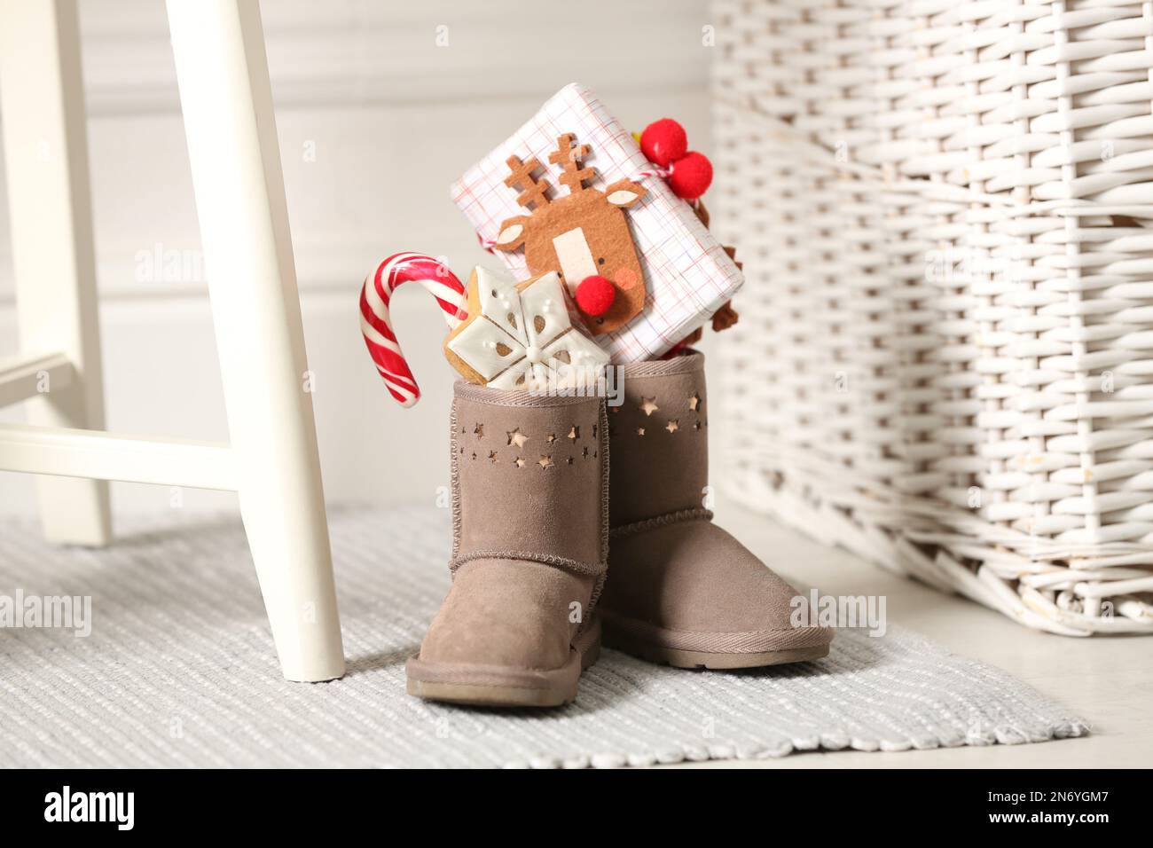 Sweets and gift box in child's boots indoors. St. Nicholas Day ...
