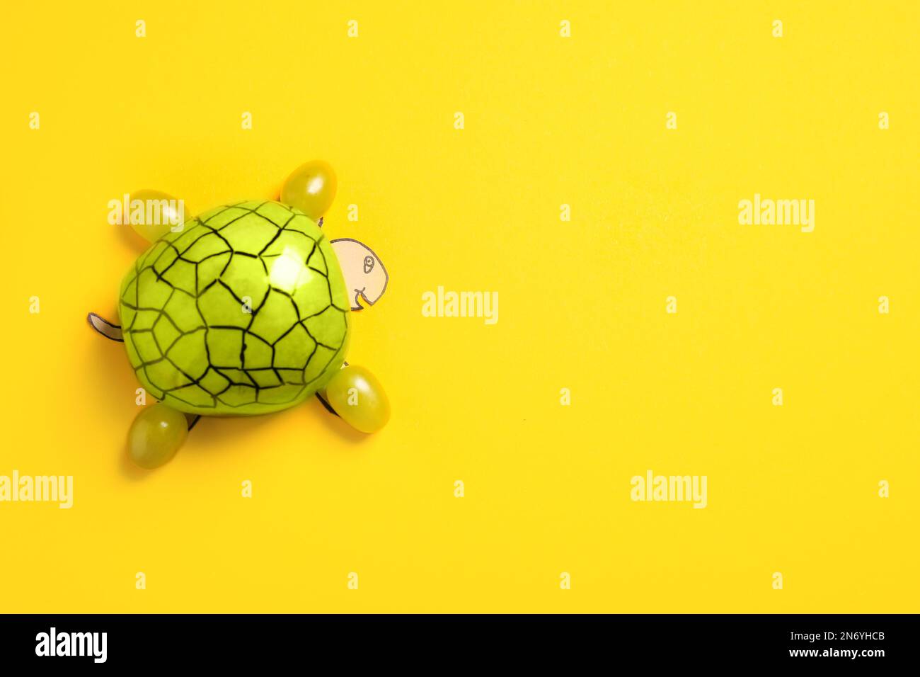 Funny turtle made of grapes on color background, top view. Space for ...