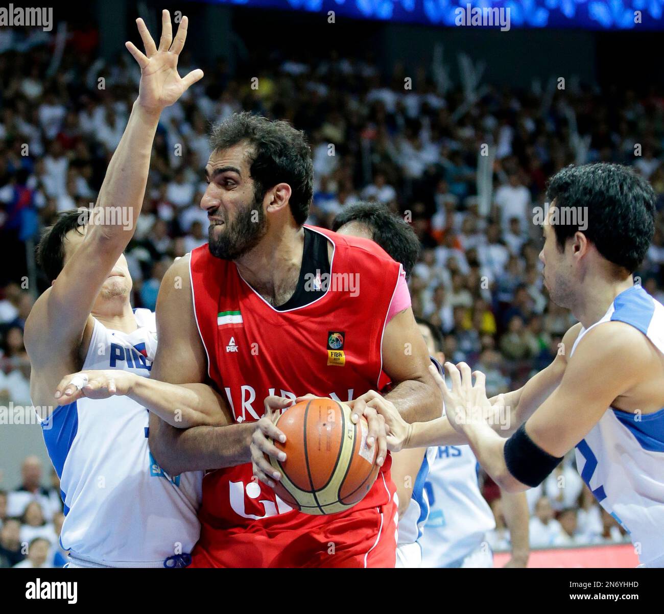 Iran's Hamed Hadadi, center, is fouled by the Philippines' Jean Marc ...