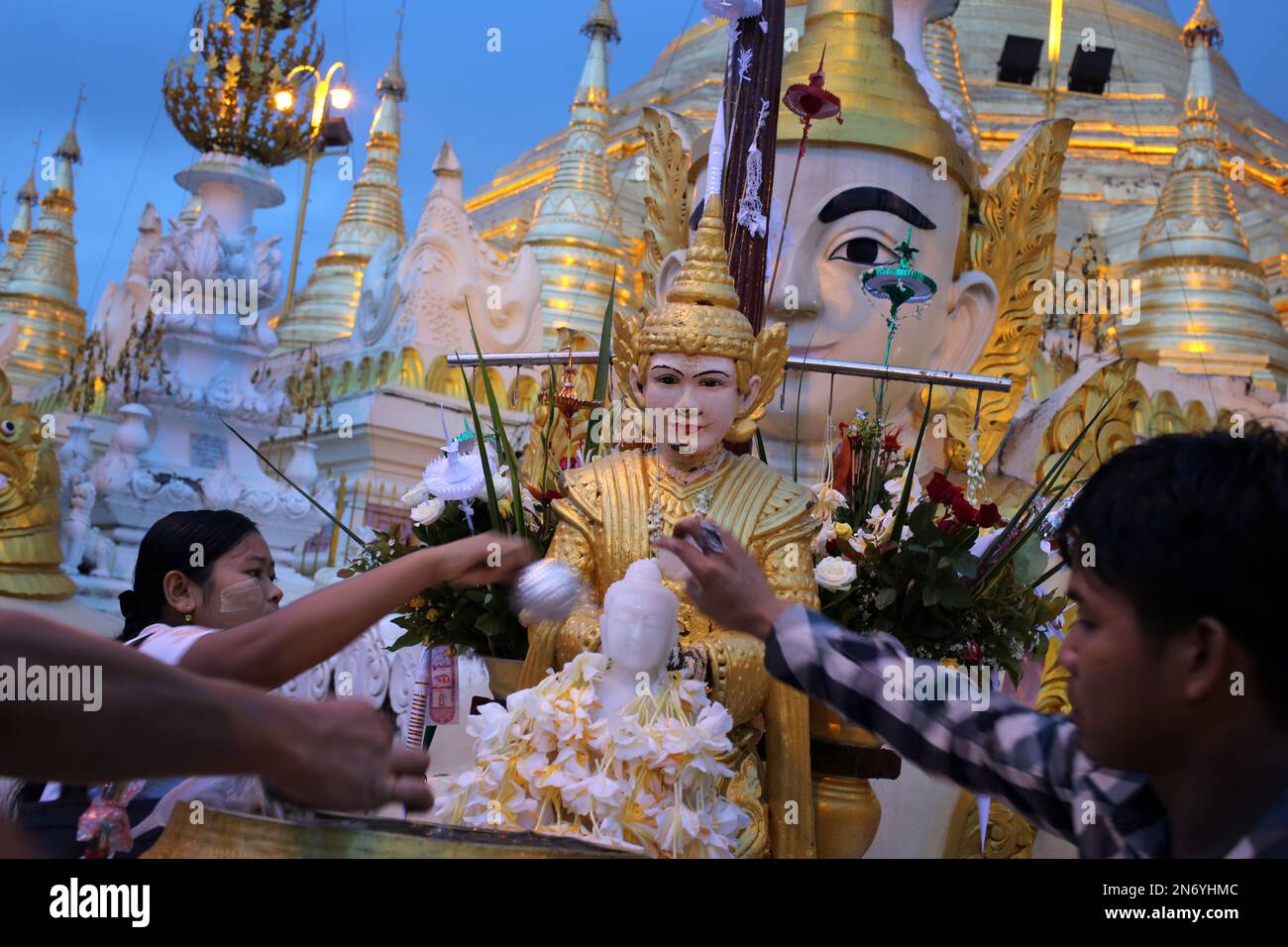 Buddhists pour water onto the statue of Buddha as part of their ...