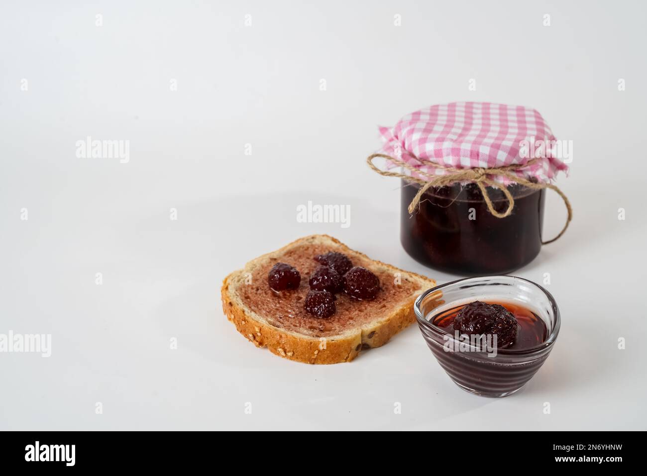 Homemade strawberry jam, jar, small bowl and a slice of bread with jam ...