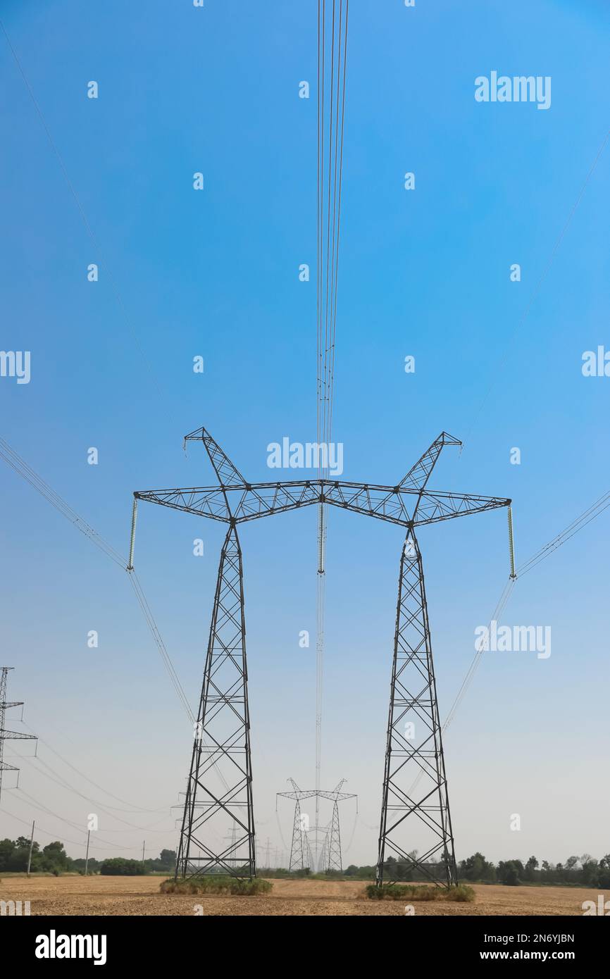 High voltage towers with electricity transmission power lines in field ...