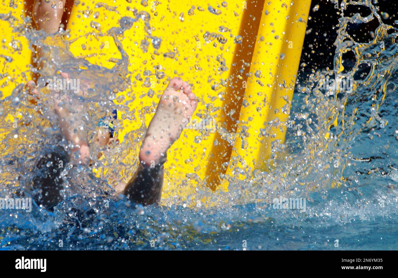A Taiwanese boy gets a splash of water to cool down in summer heat at ...