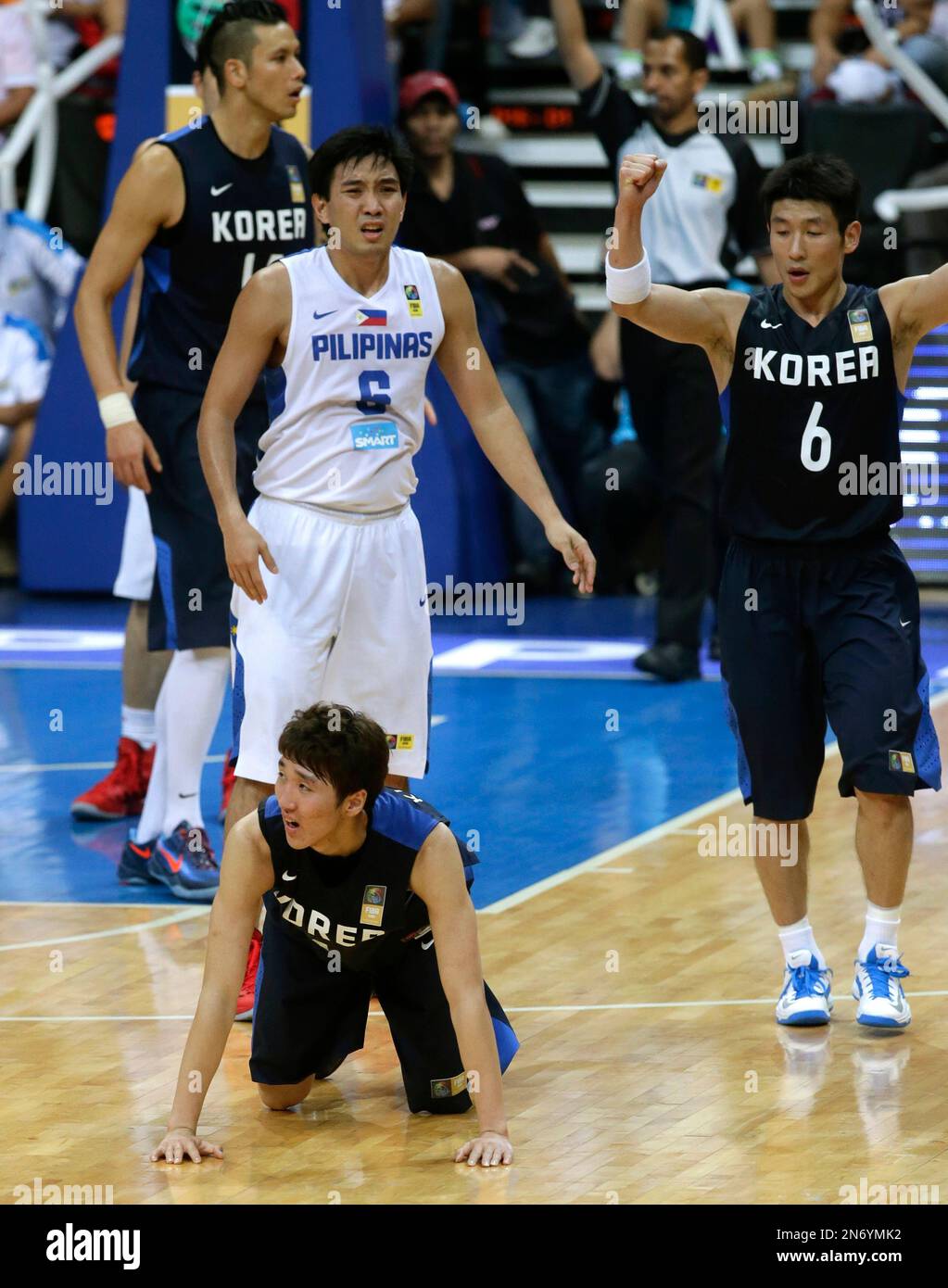 South Korea's Kim Mingoo falls to the court for a three-point play ...