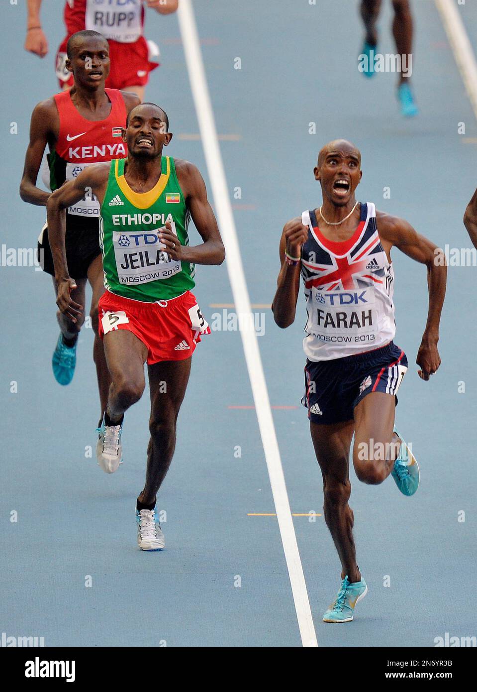 Britain's Mo Farah, right, runs to cross the finish line ahead of ...