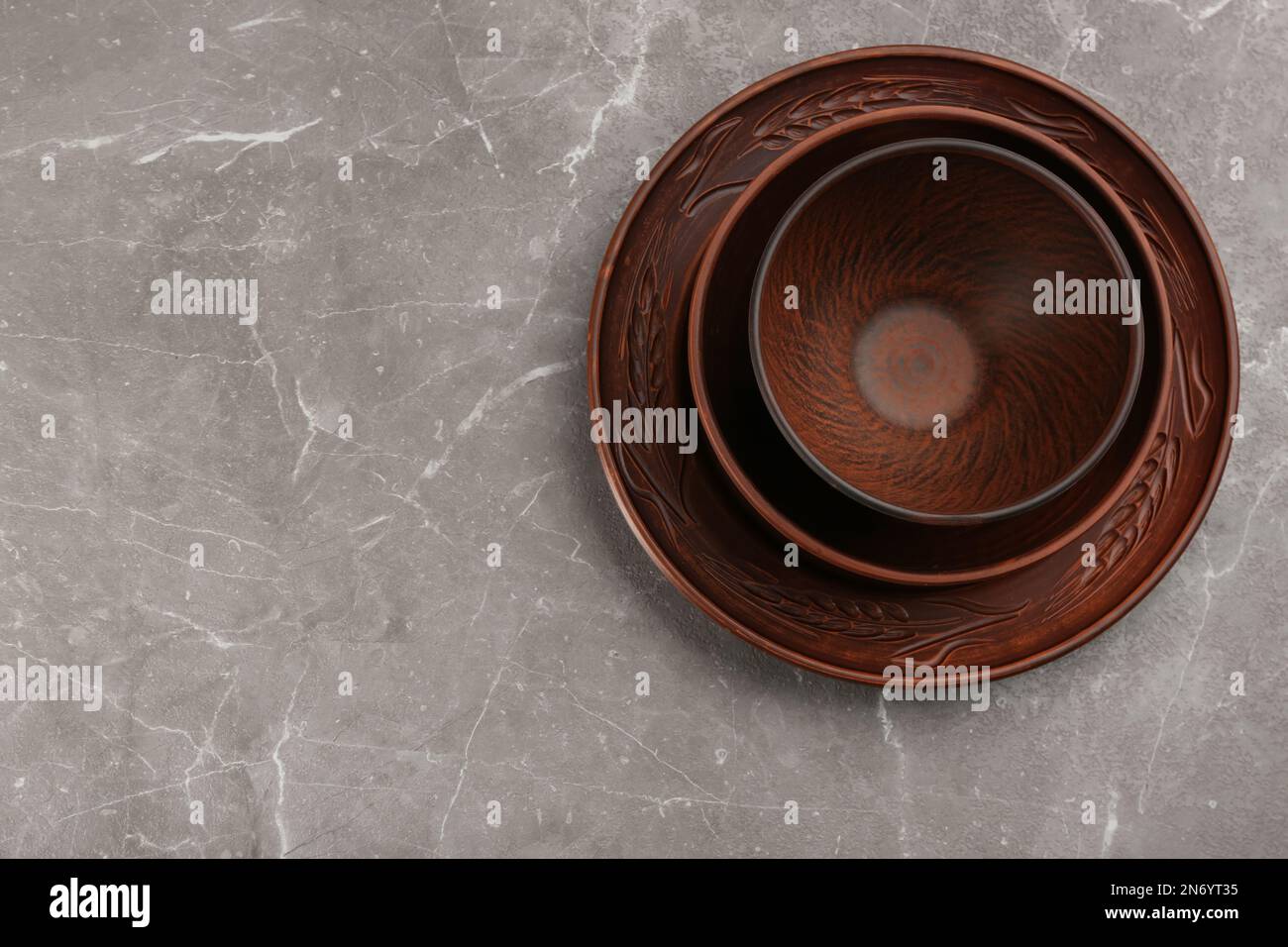 Set of clay dishes on grey marble table, top view. Space for text Stock ...