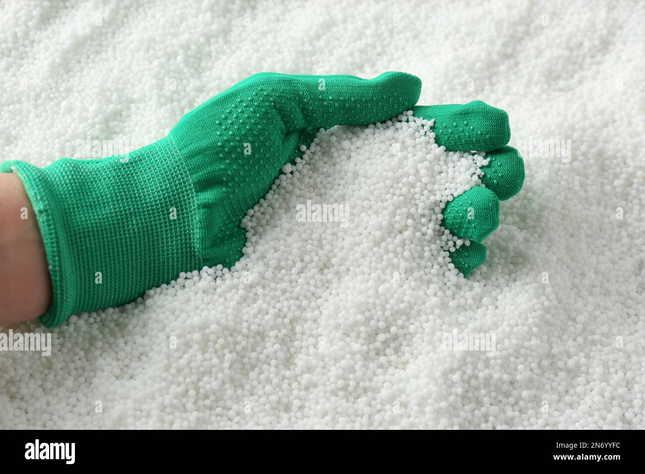 Farmer taking pellets of ammonium nitrate from pile, closeup. Mineral ...