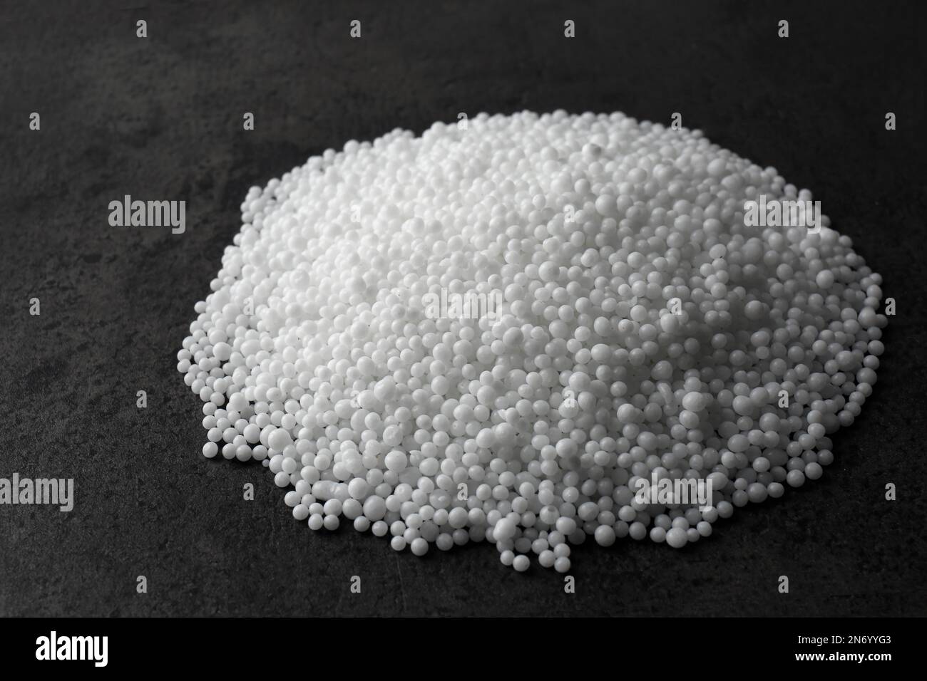 Pellets of ammonium nitrate on grey table. Mineral fertilizer Stock ...