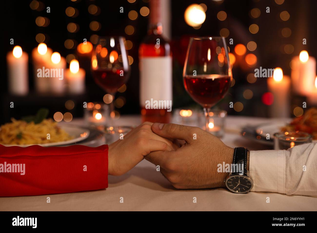 Couple holding hands dinner table hi-res stock photography and images ...
