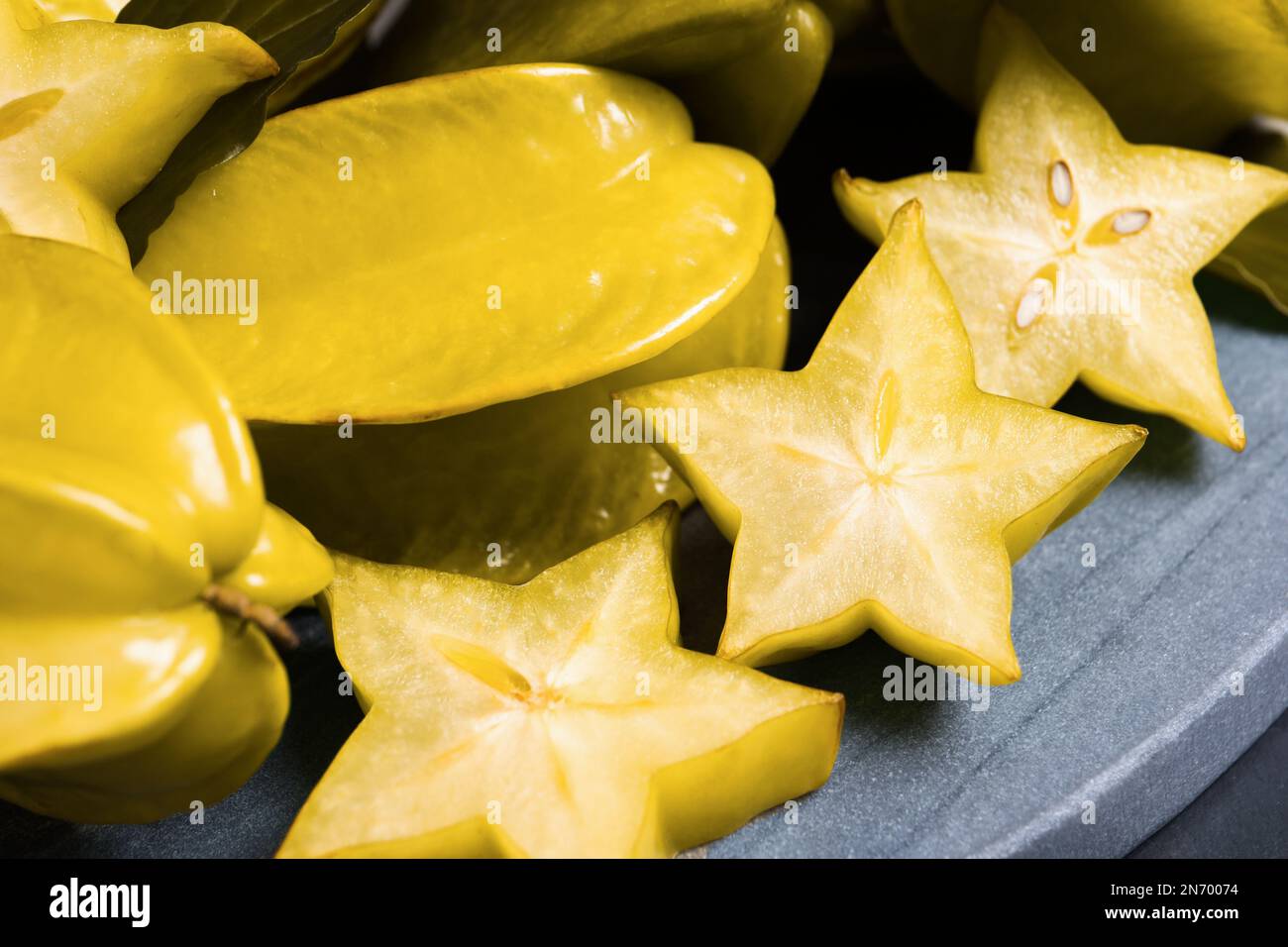 Cut and whole carambolas on board, closeup Stock Photo - Alamy