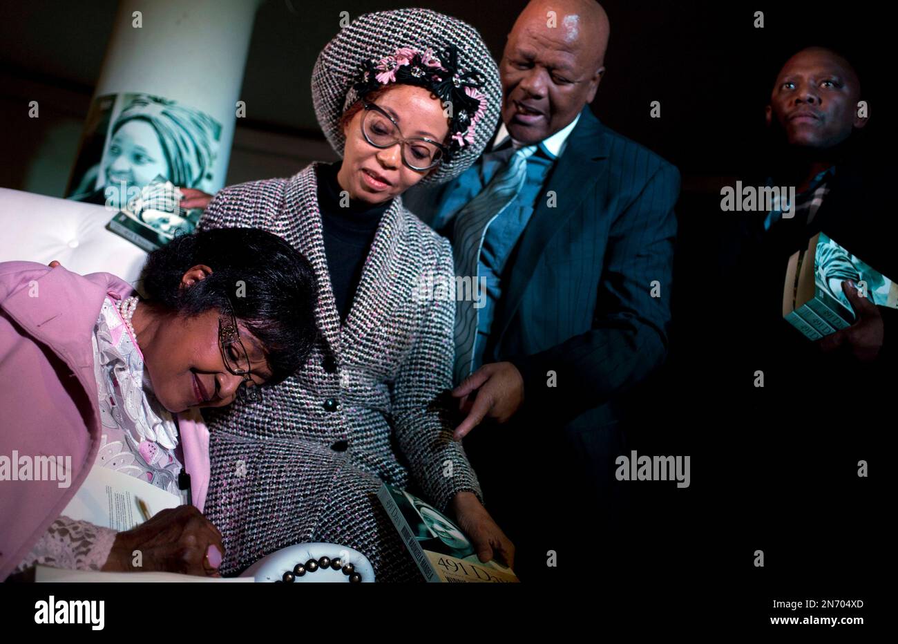 Winnie Madikizela-Mandela, left, signs a copy of her book for Justice ...