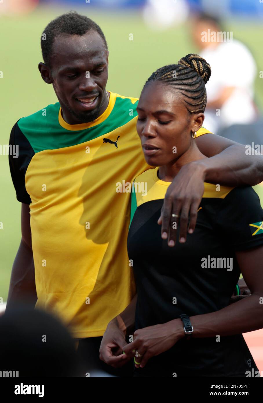 Jamaica's Usain Bolt, left, puts an arm on the shoulder of his teammate ...