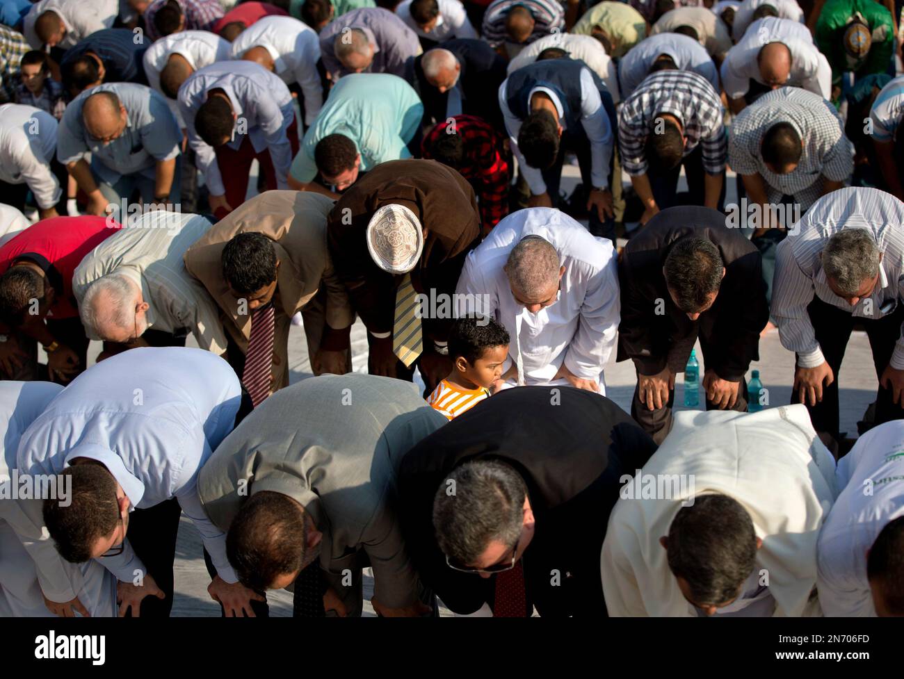 A child runs between lines of Muslim men during Eid al-Fitr prayers in ...