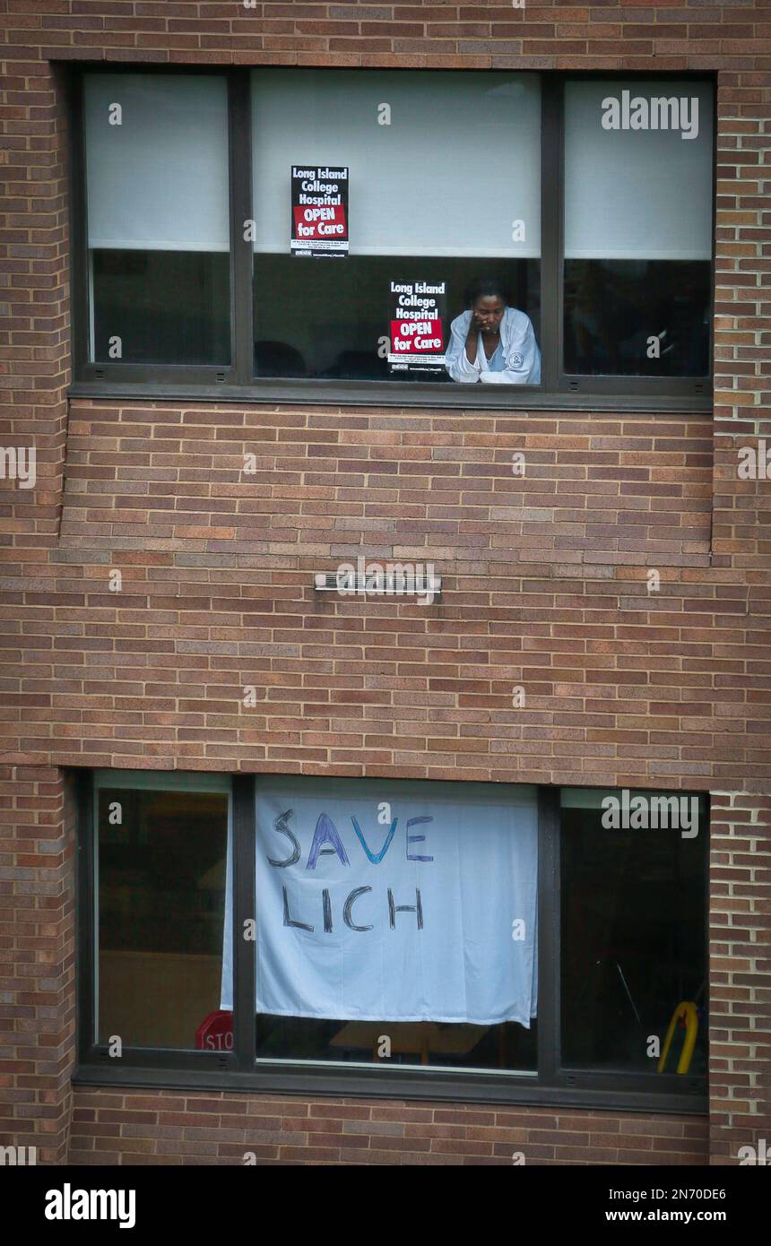 A woman stares out of a window next to signs calling for Long Island ...