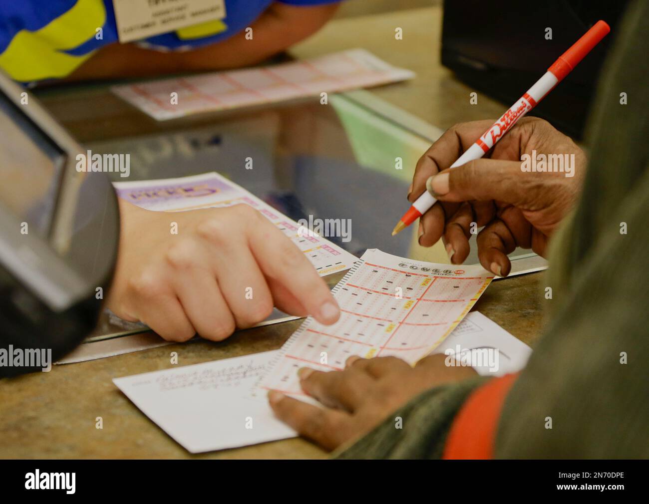 A customer fills out her powerball form at a Baker's supermarket in ...