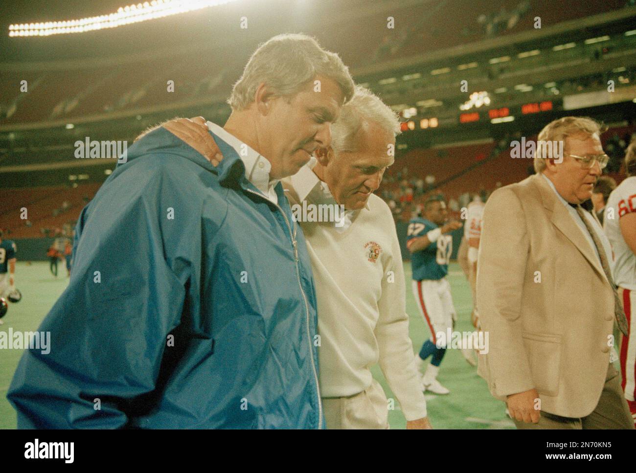 San Francisco 49ers coach Bill Walsh, right, leaves Giants Stadium with ...