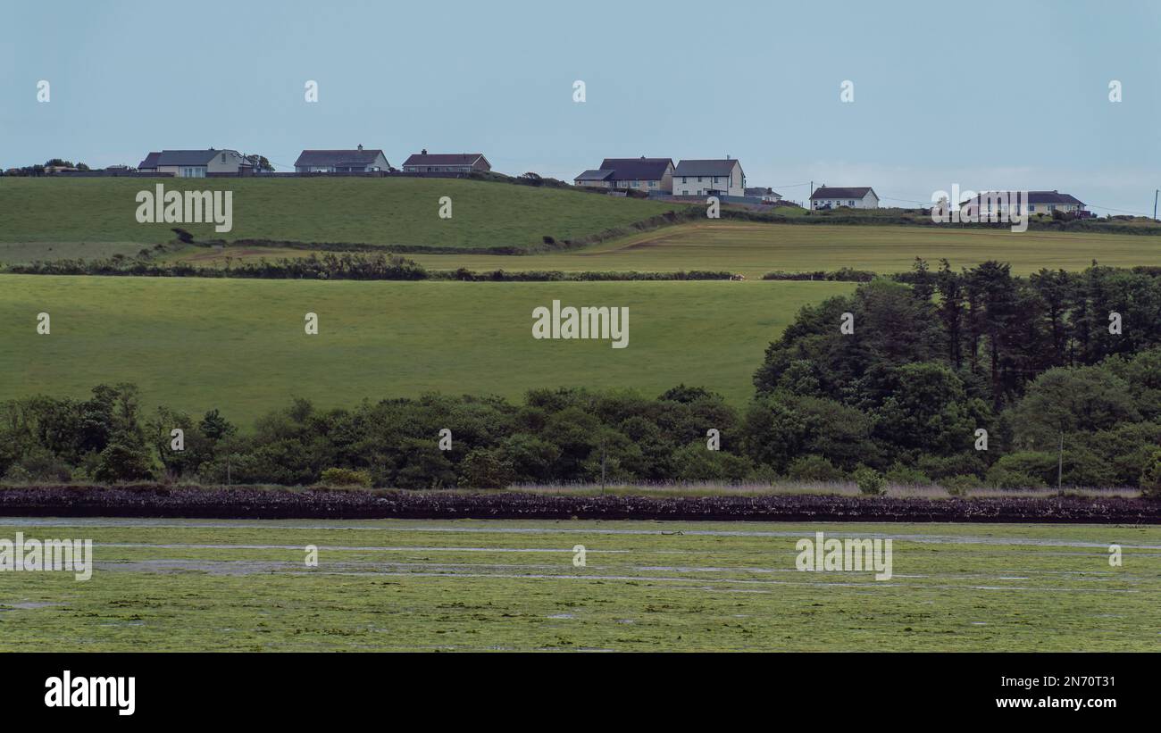 A houses on a hill, sky on a summer day. A small Irish village. The ...
