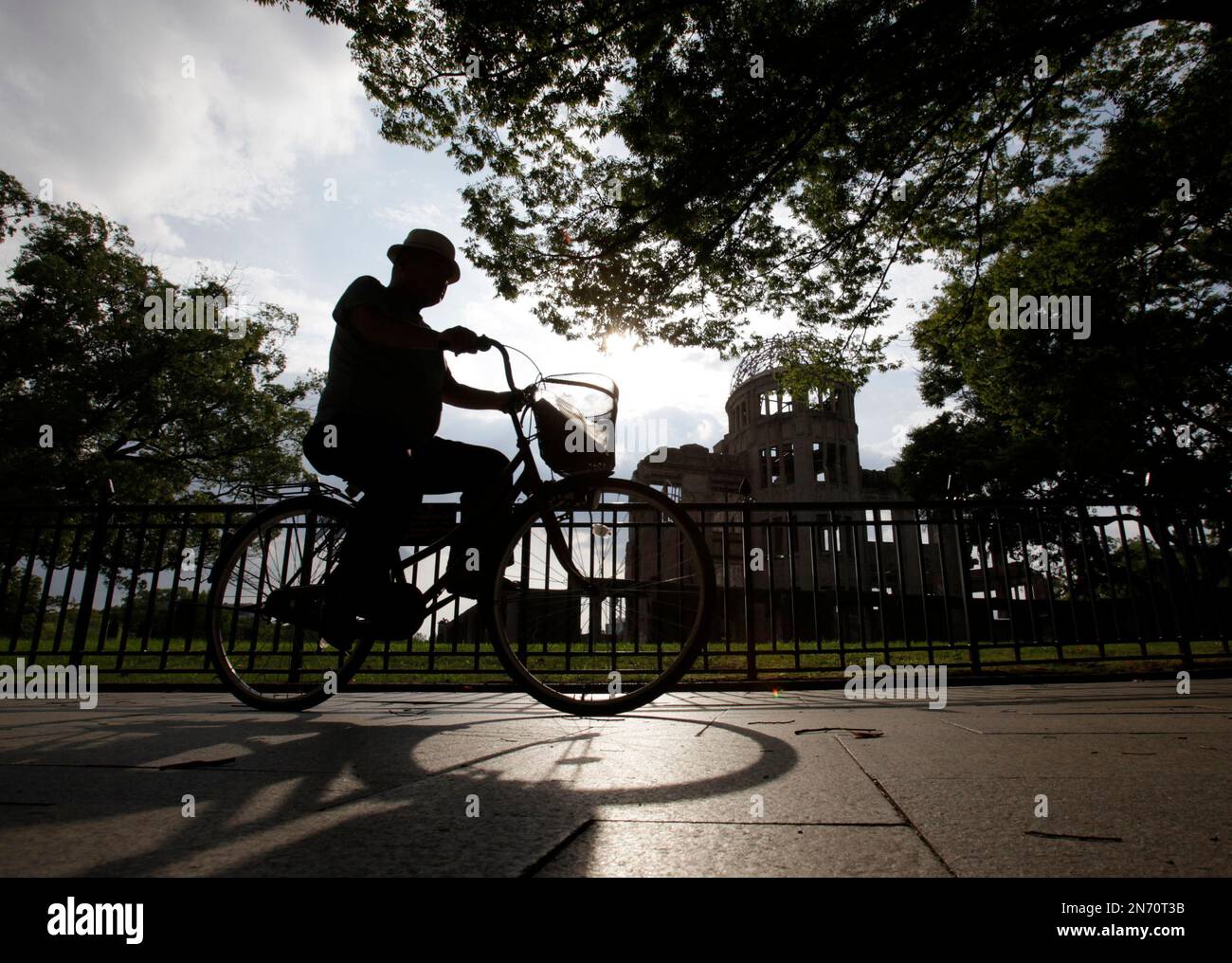 A man rides on a bicycle past the Atomic Bomb Dome in Hiroshima ...