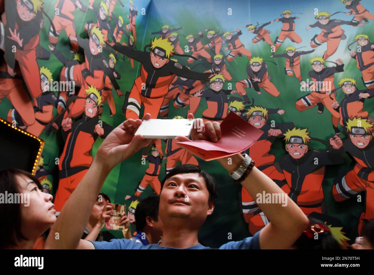 A fan takes a photo at an exhibition of Japanese ninja manga "Naruto ...