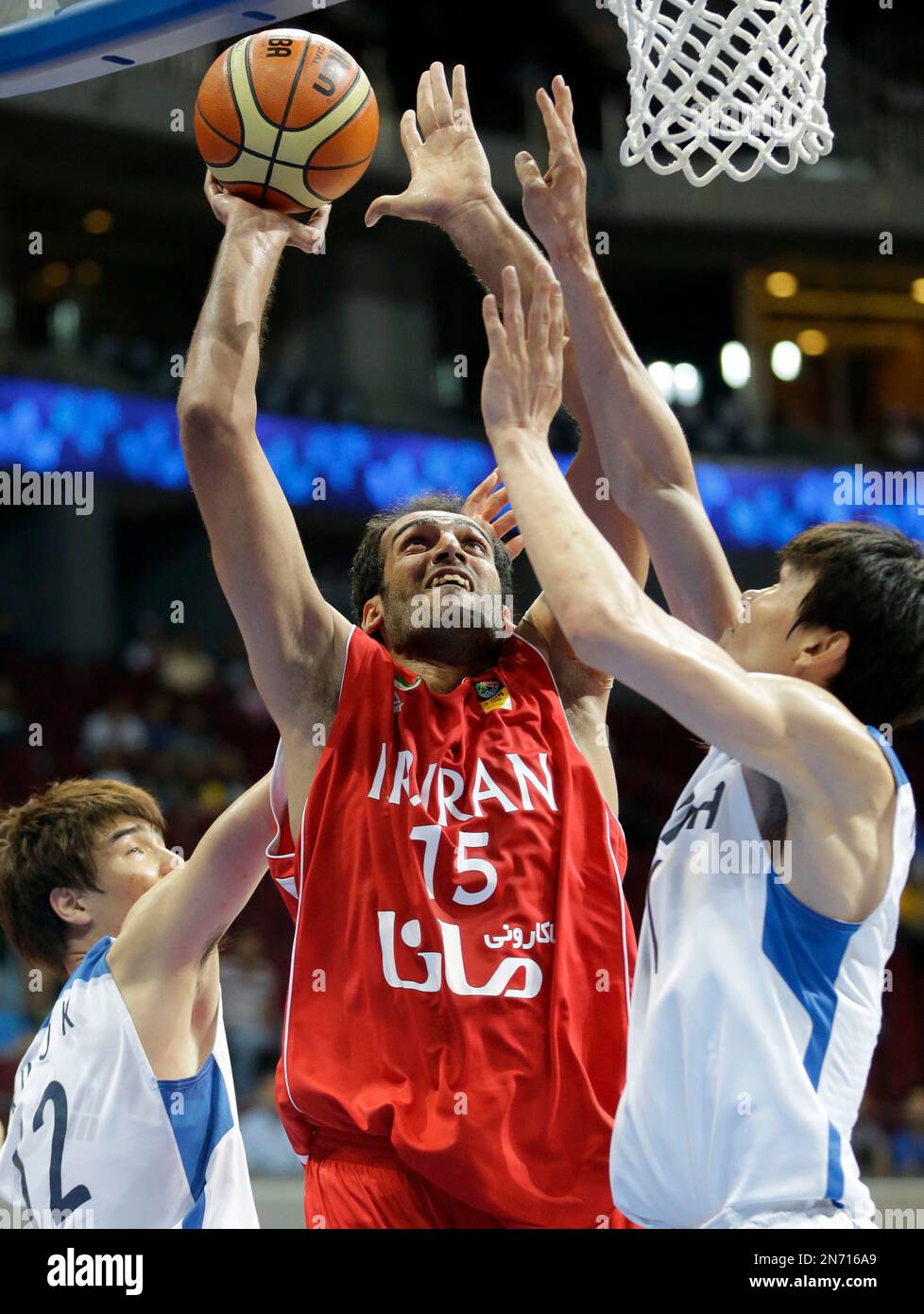 Iran's Hamed Hadadi (15) attempts a shott over South Korea's Kim Jong ...