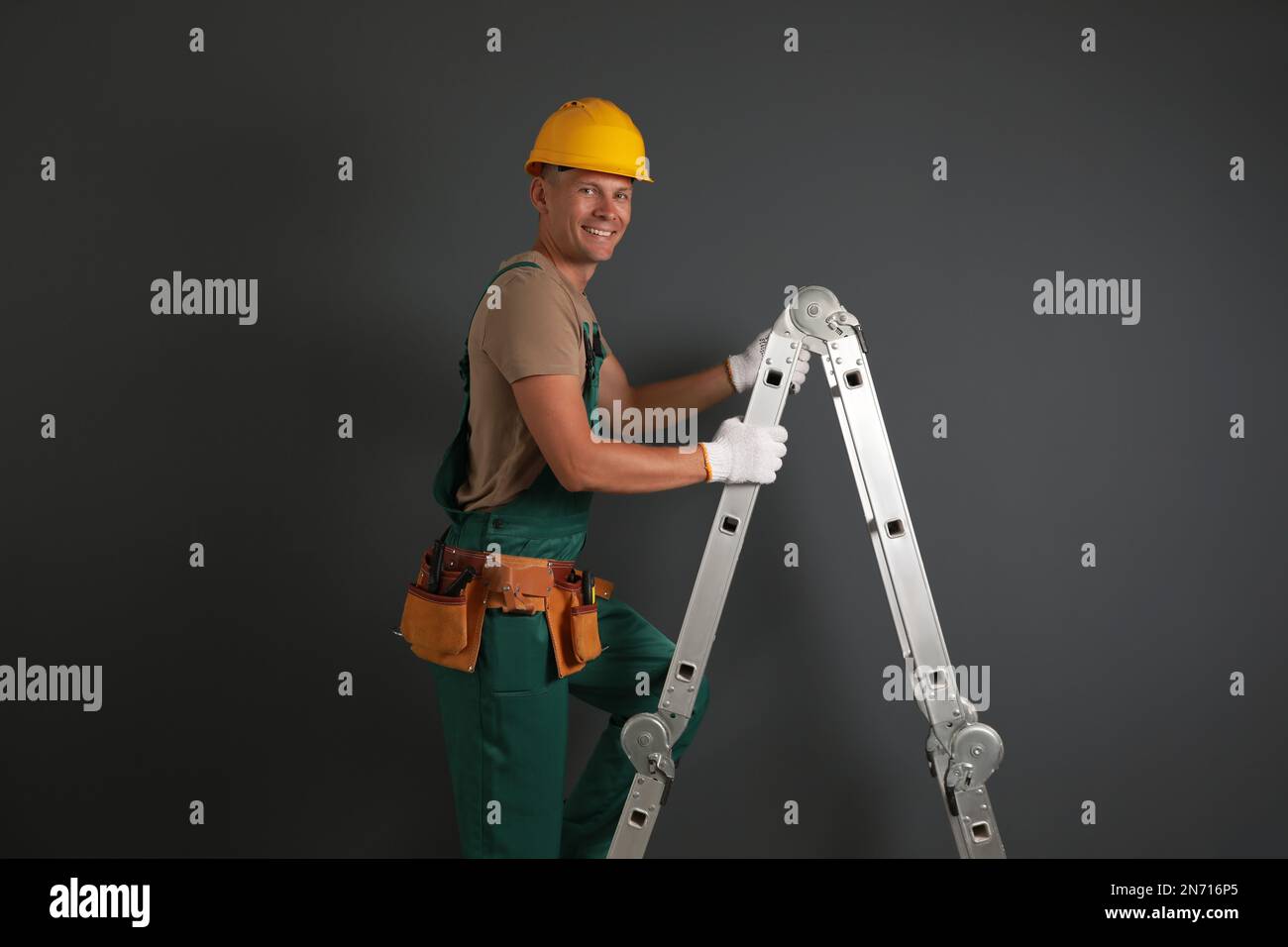 Professional constructor climbing ladder on black background Stock ...