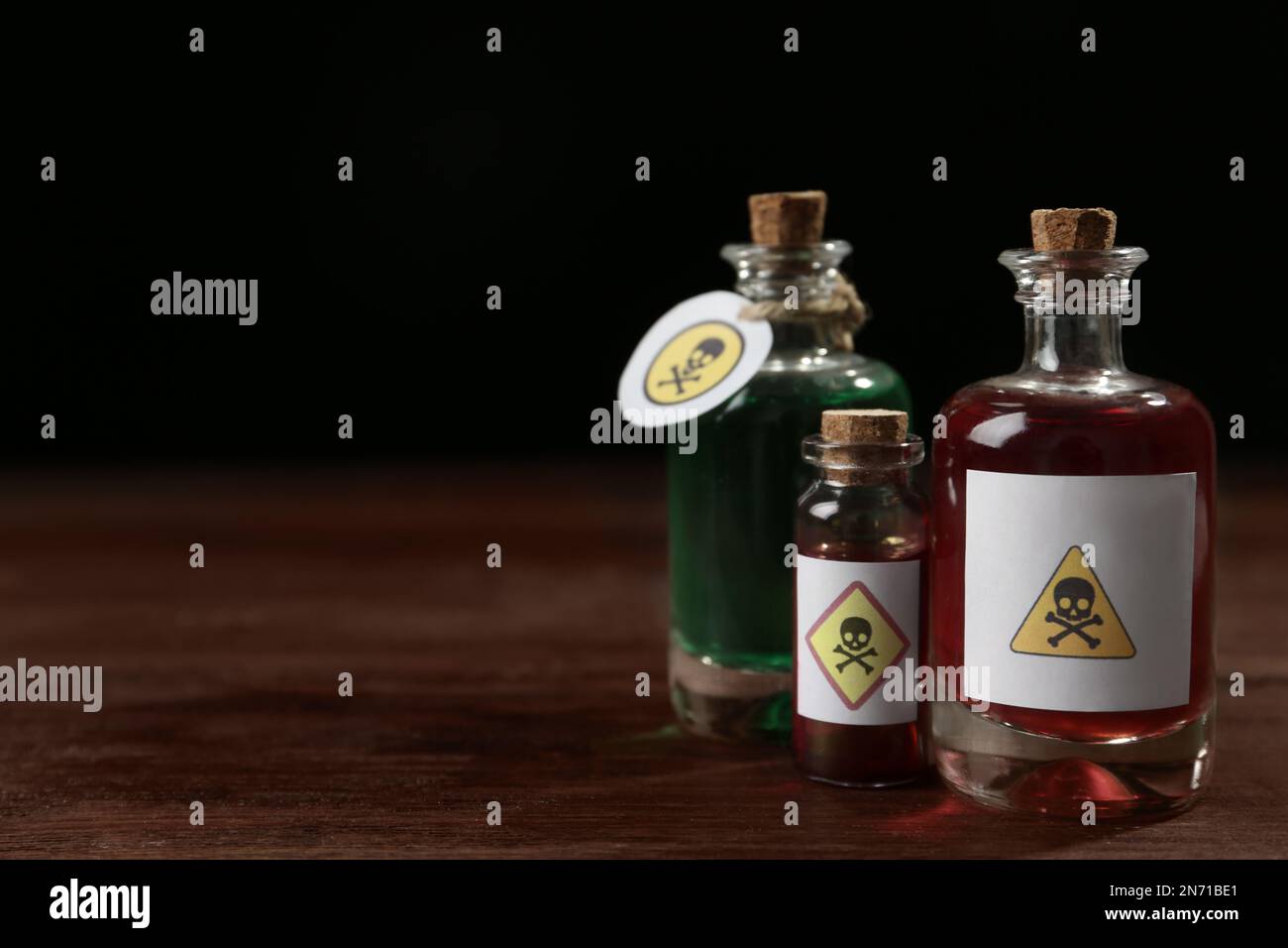 Bottles with poisons on wooden table. Space for text Stock Photo - Alamy
