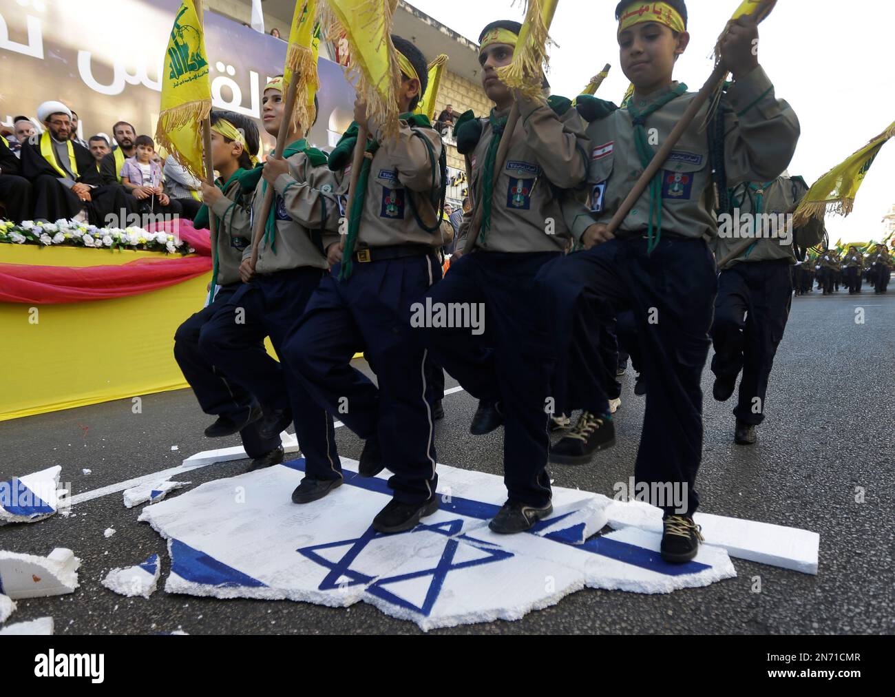 Hezbollah al-Mahdi scouts march over a representation of an Israli flag ...